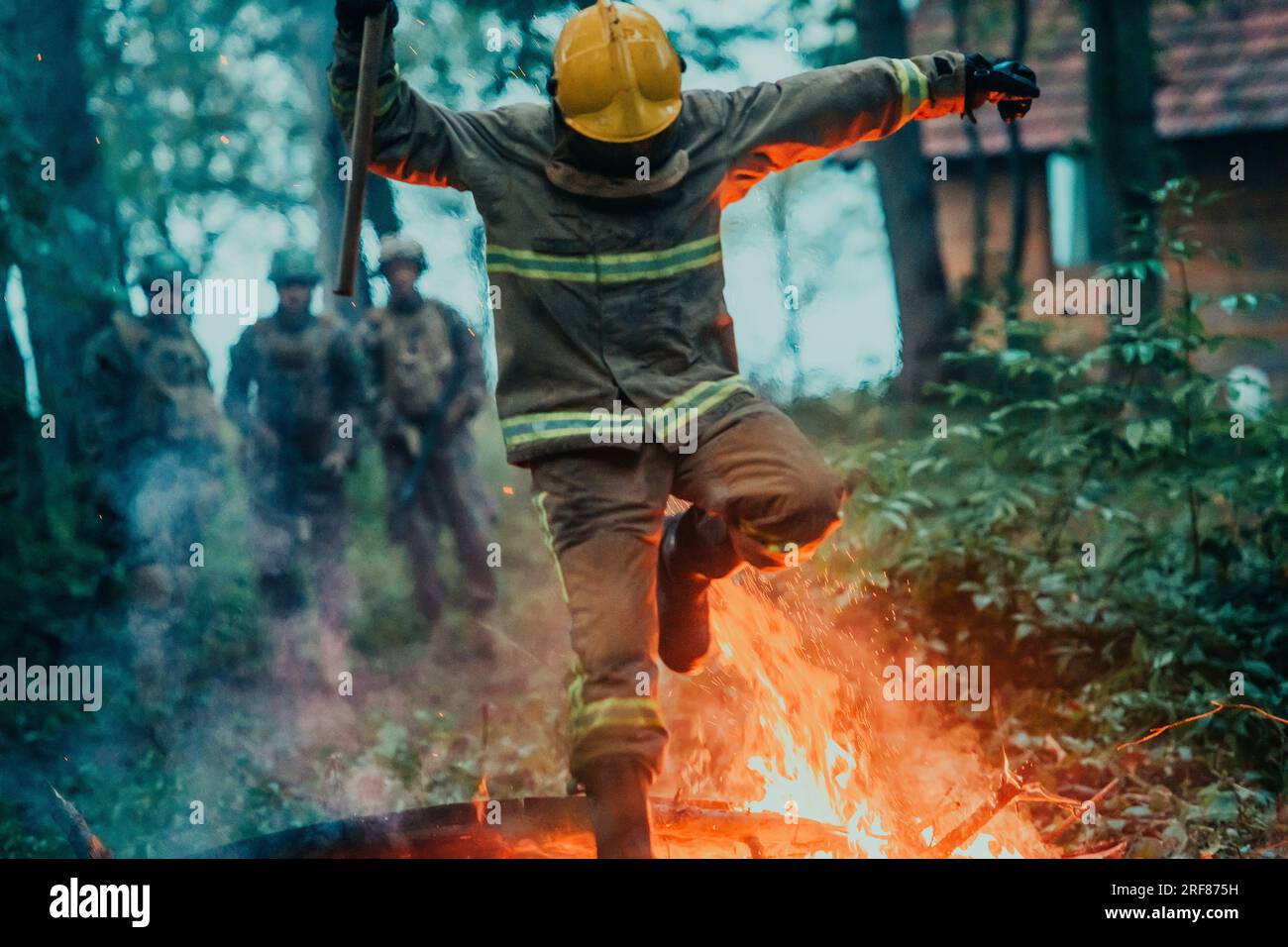 firefighter hero in action danger jumping over fire flame to rescue and ...