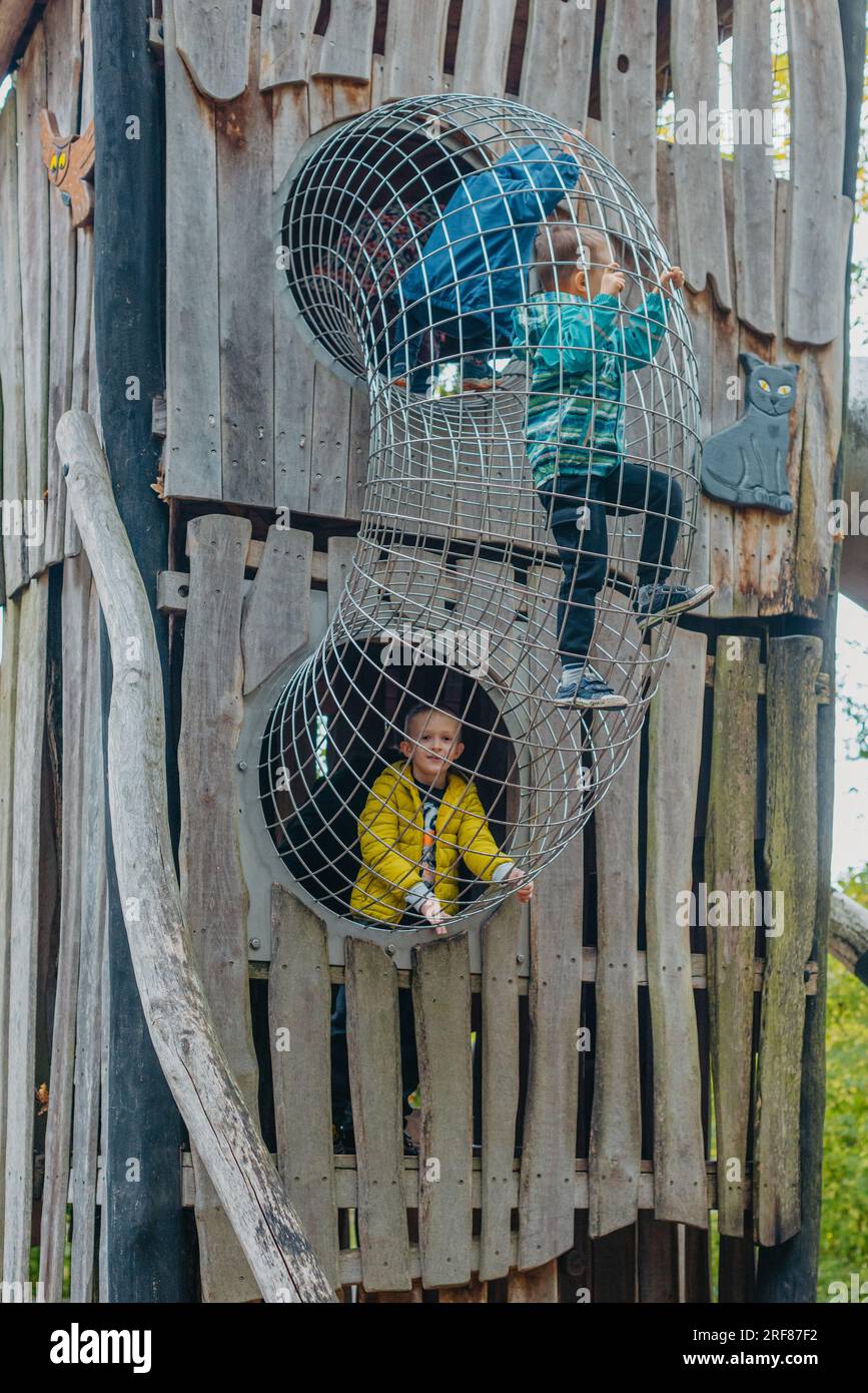 A child climbs up an alpine grid in a park on a playground on a hot ...