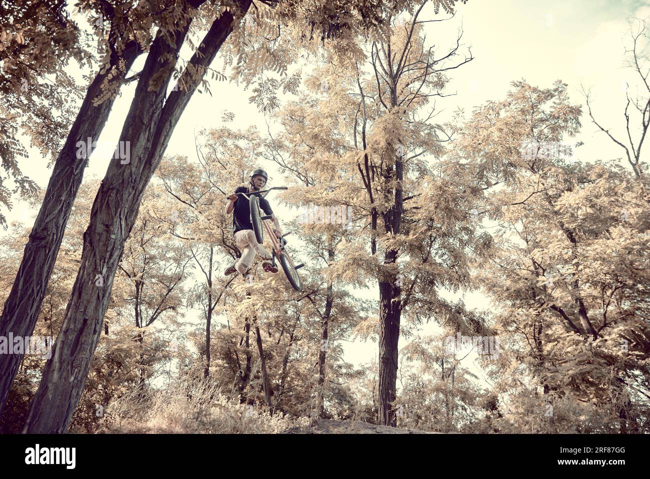 Dangerous activity. Young man, professional rider training in forest ...
