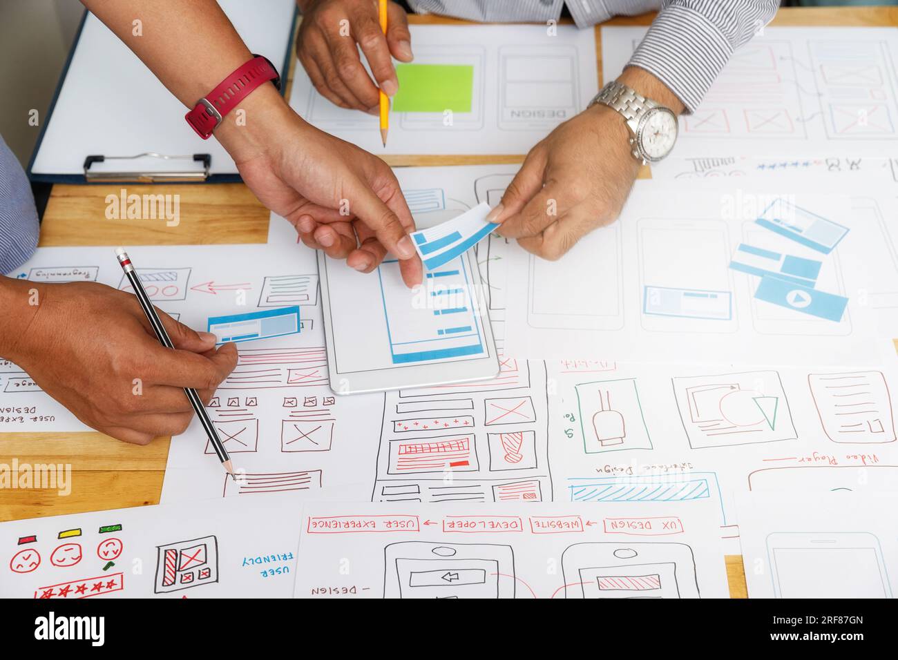UX or UI designers designing on their smartphone application layout ...