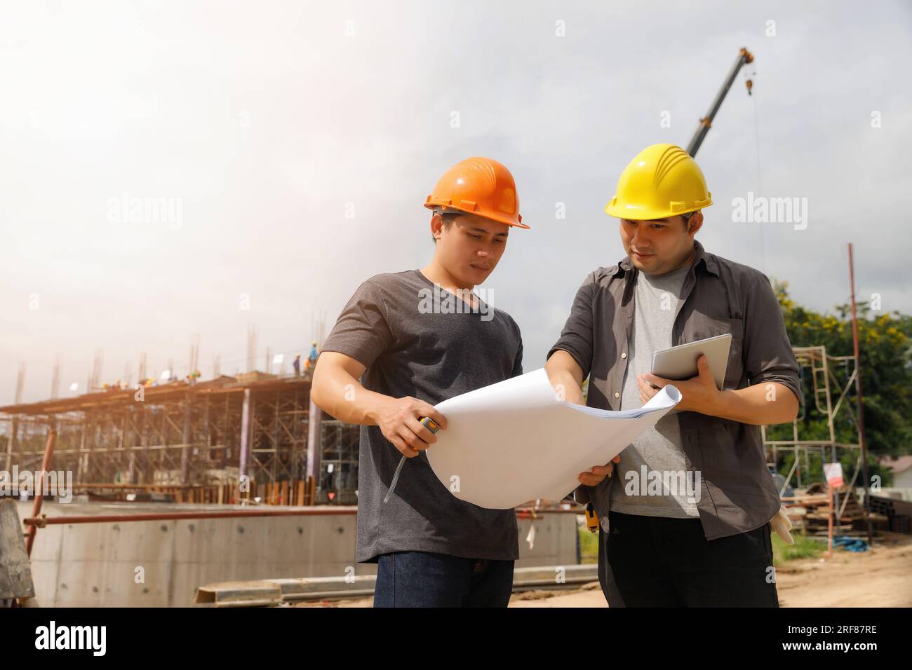 Team of construction workers discussing project details with blueprint ...