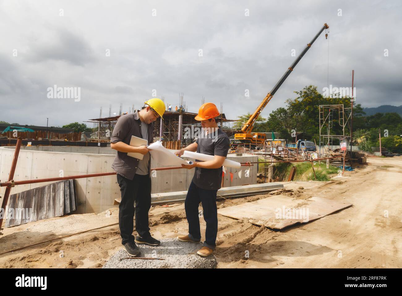 Team of construction workers discussing project details with blueprint ...