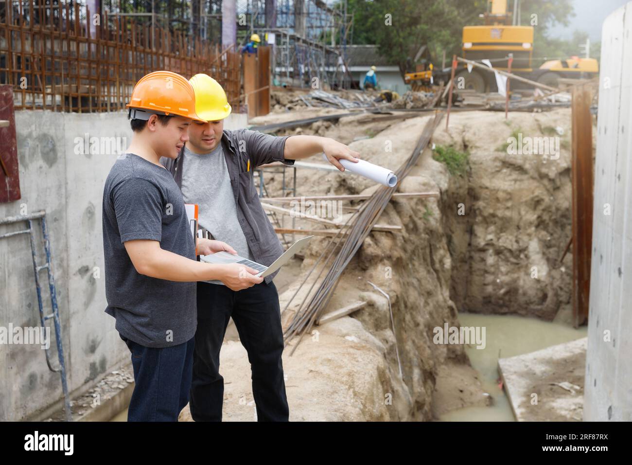 Team of construction workers discussing project details with blueprint ...