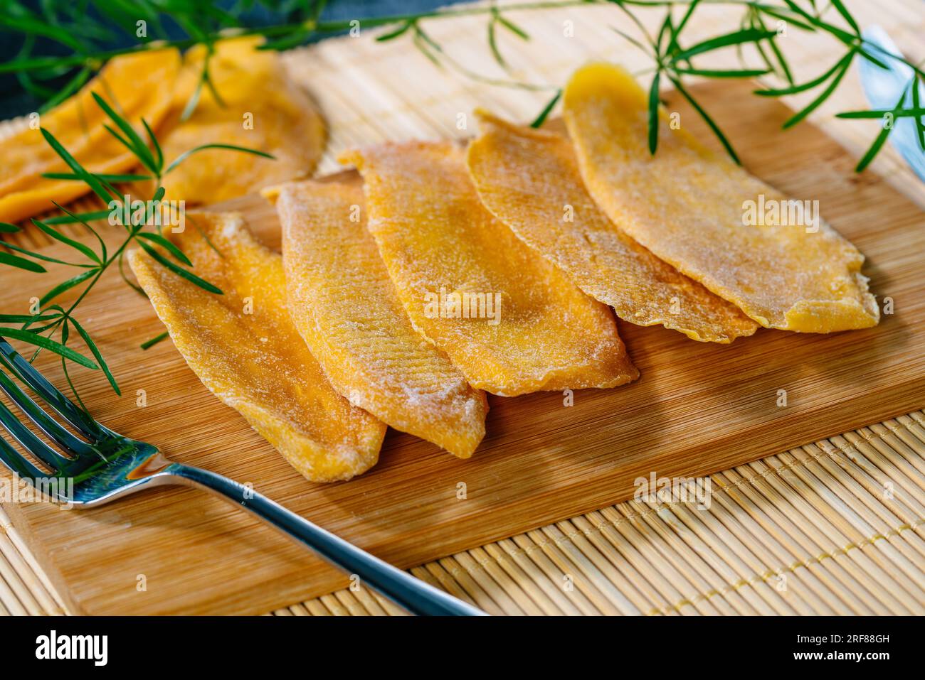 Kitchen table with dried mango on board Stock Photo - Alamy