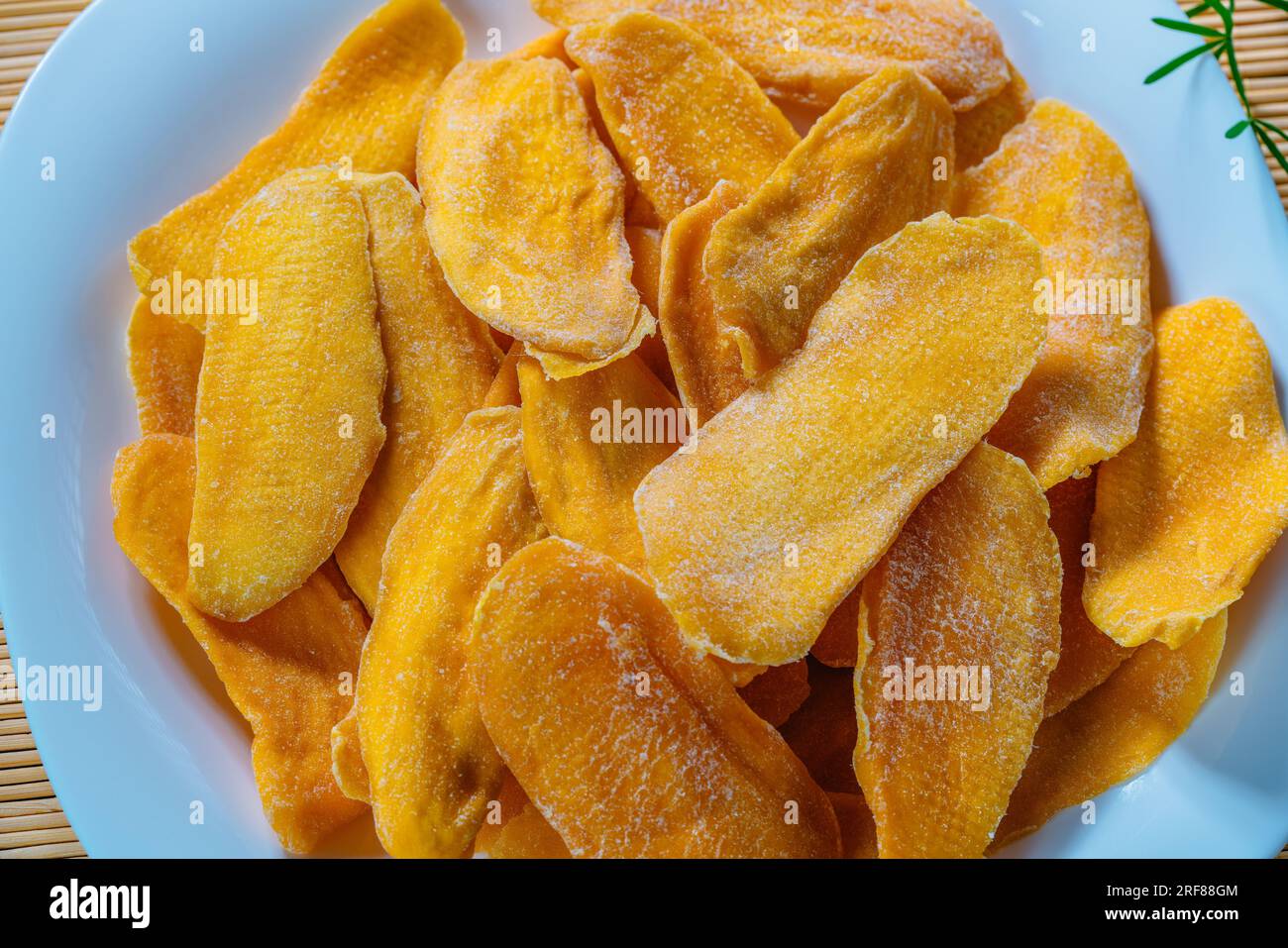 Dried mango on white plate close-up Stock Photo - Alamy