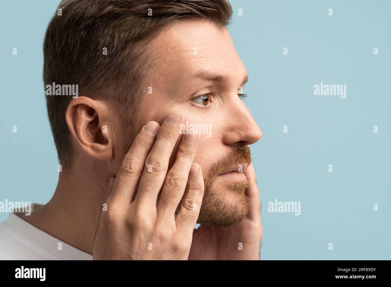 Portrait of bearded sad man touching face skin having anxiety about ...