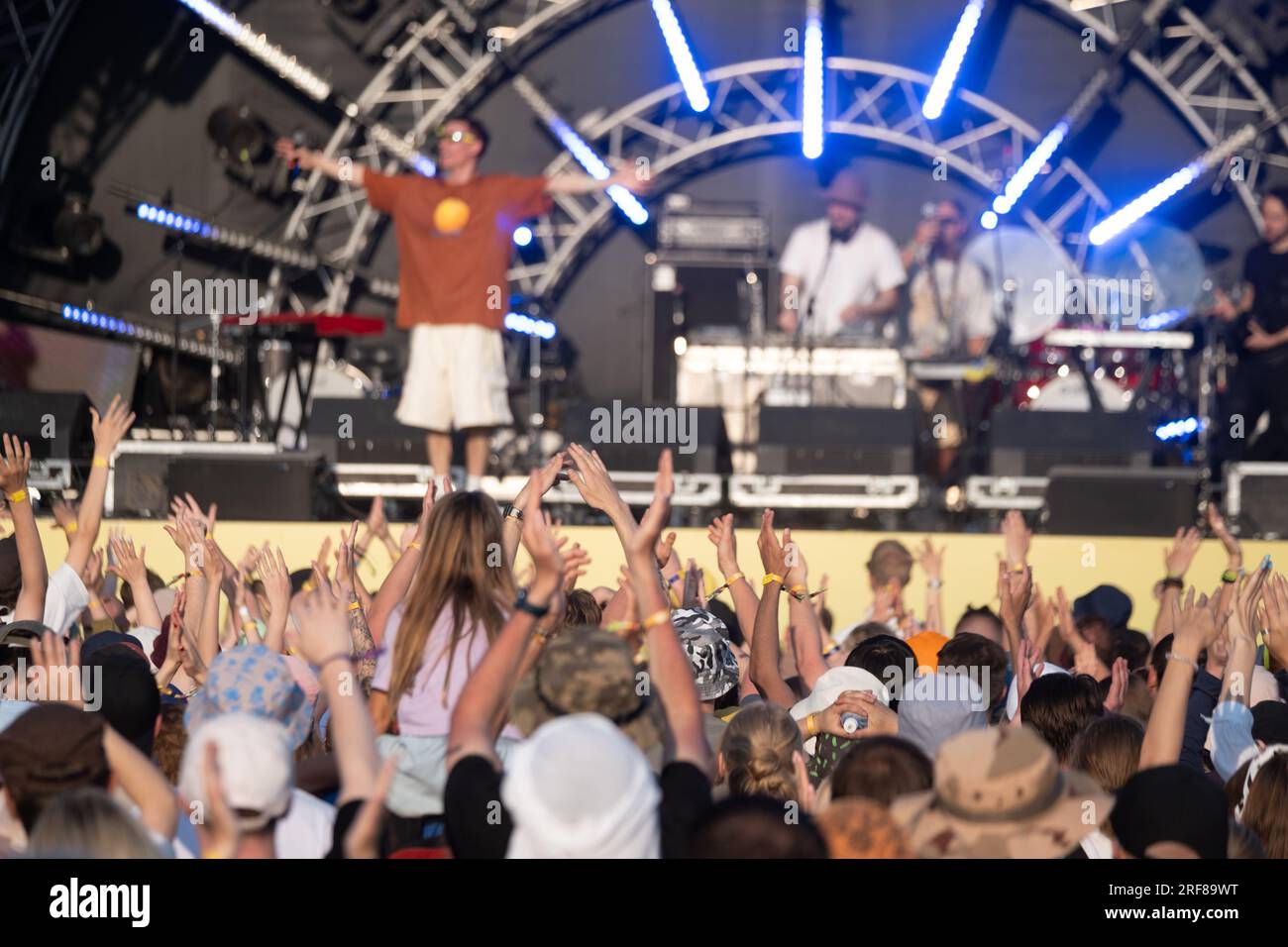 Blurred musical group members performing on stage for excited crowd of ...