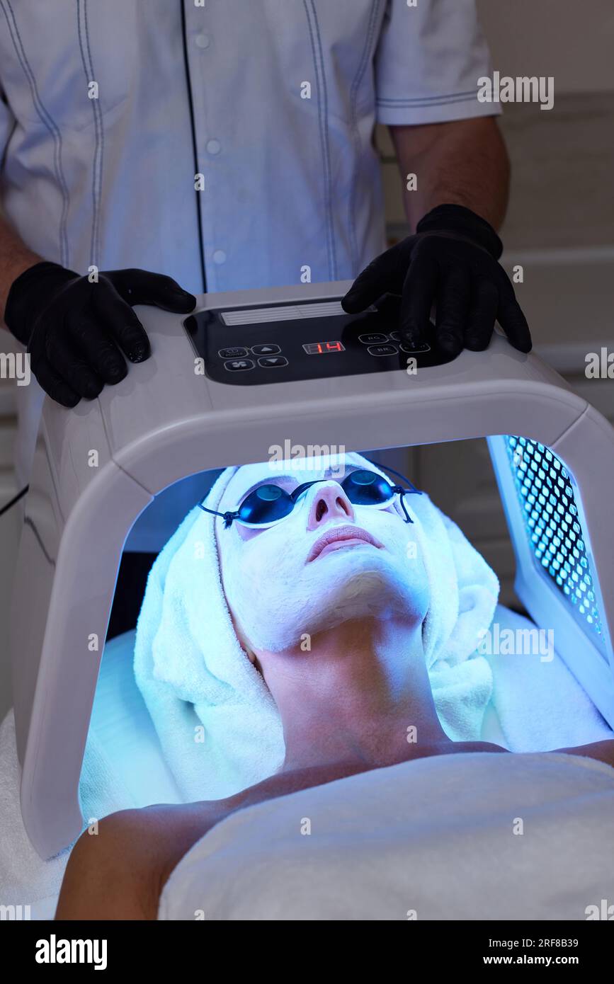 Woman getting facial treatment with led therapy Stock Photo - Alamy