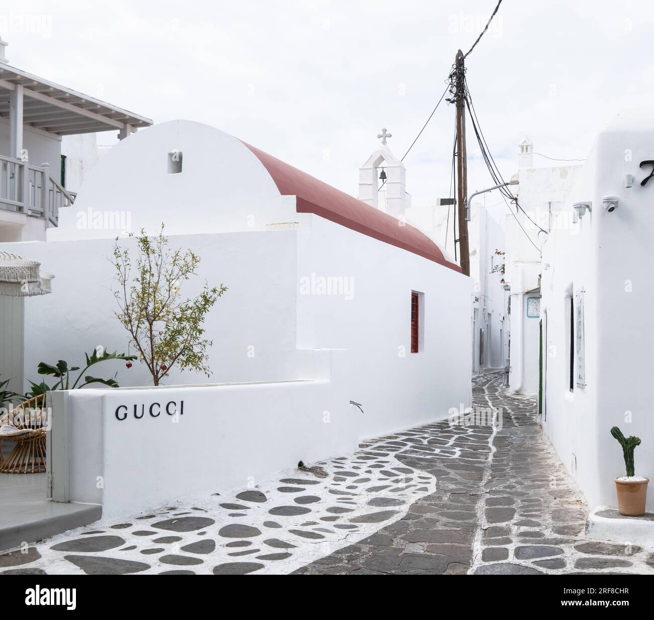 Street in Chora, Mykonos with a church with a red roof in the centre, a ...