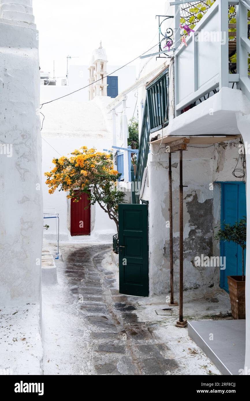 Street in Chora, Mykonos with a path leading through to an open door ...