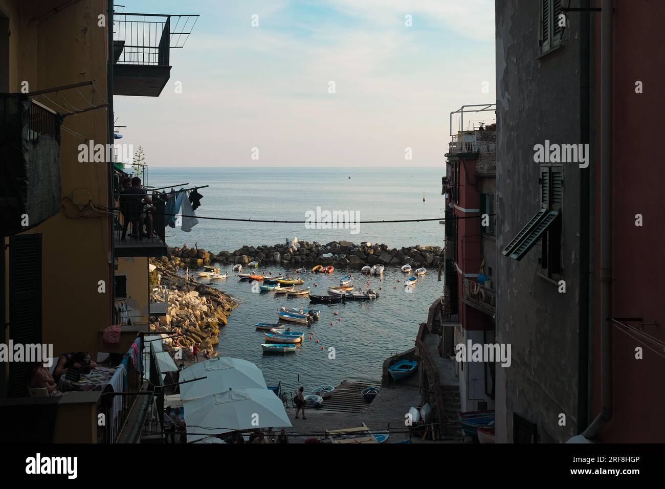 Cinque Terre, Italy - view of people in balconies, rocky harbor in ...