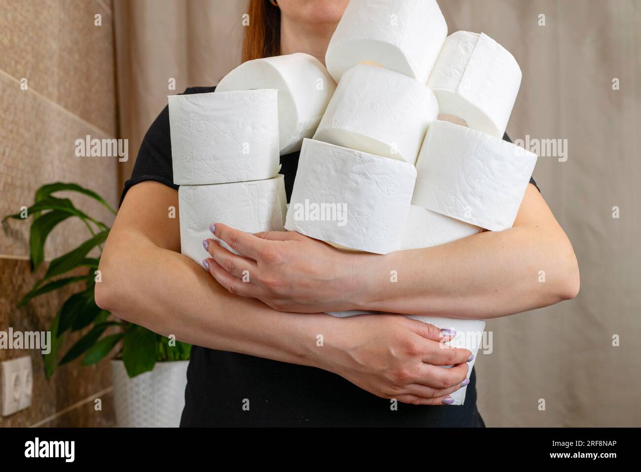 A woman holds many rolls of toilet paper Stock Photo - Alamy