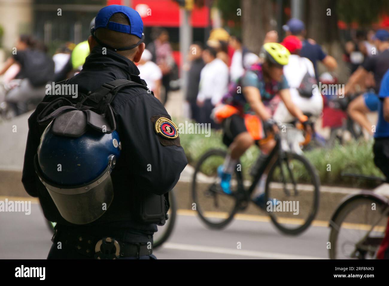 Mexico City police officer watches runners and cyclists on Paseo de la ...