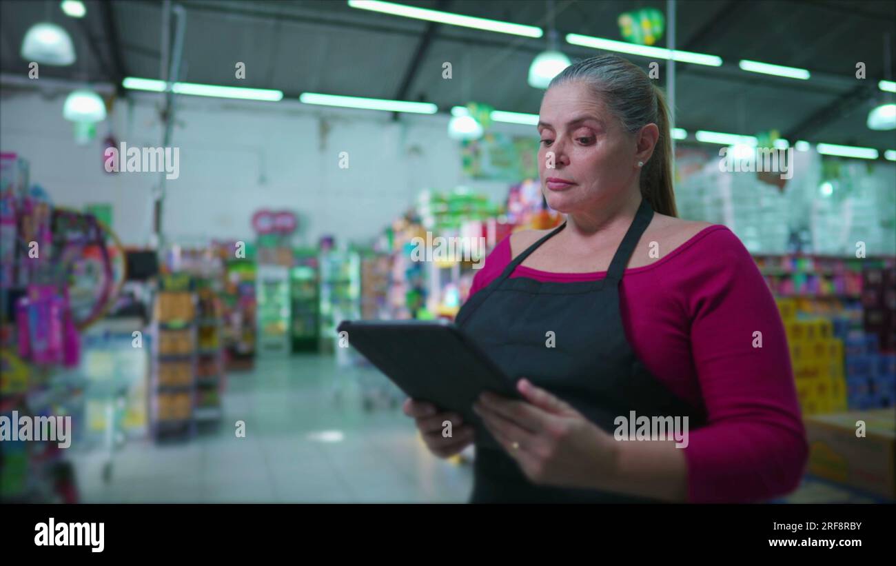 Stressed female employee of Supermarket chain standing inside business ...
