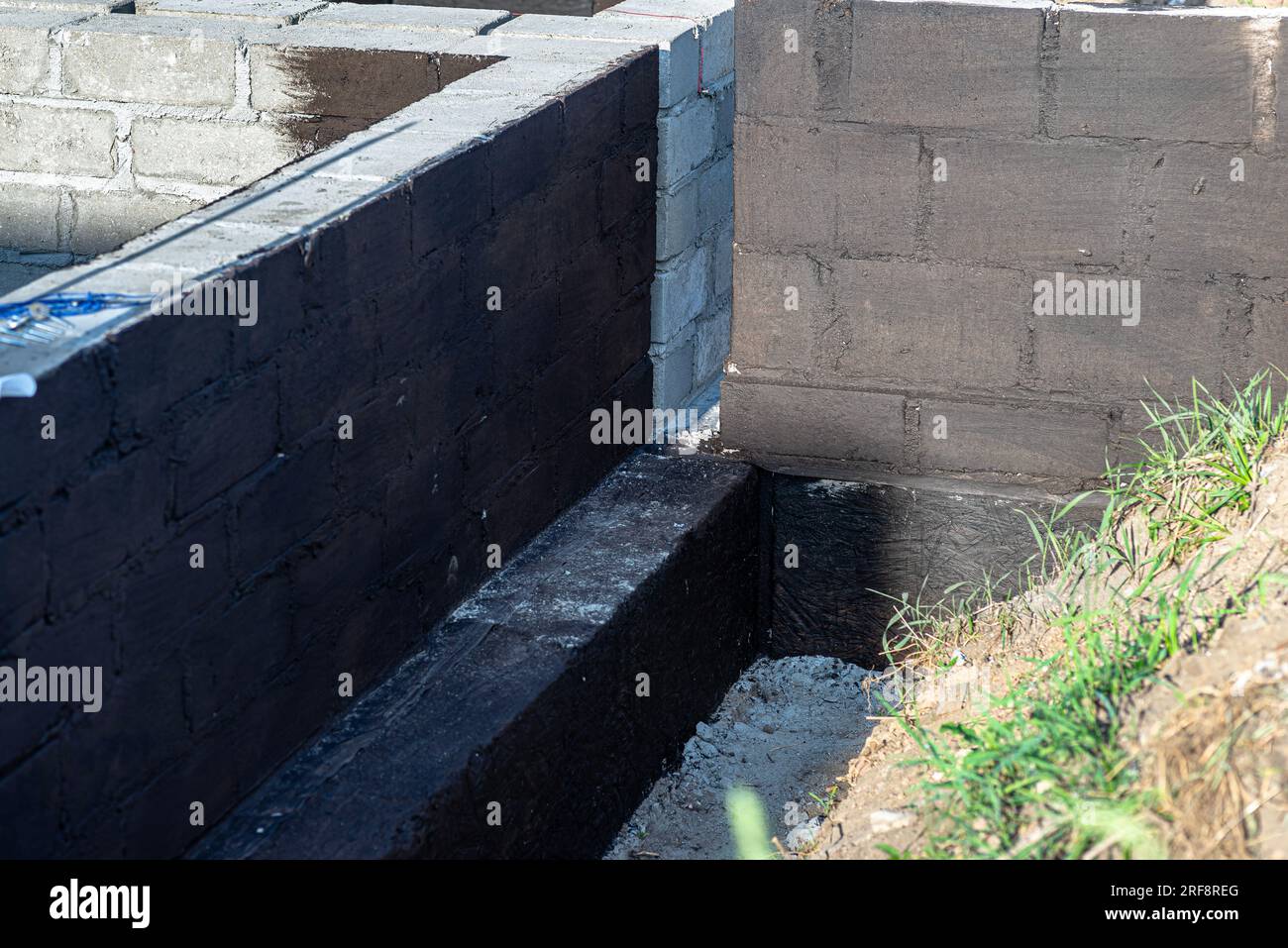 Footings made of concrete blocks painted with black dispersion asphalt ...