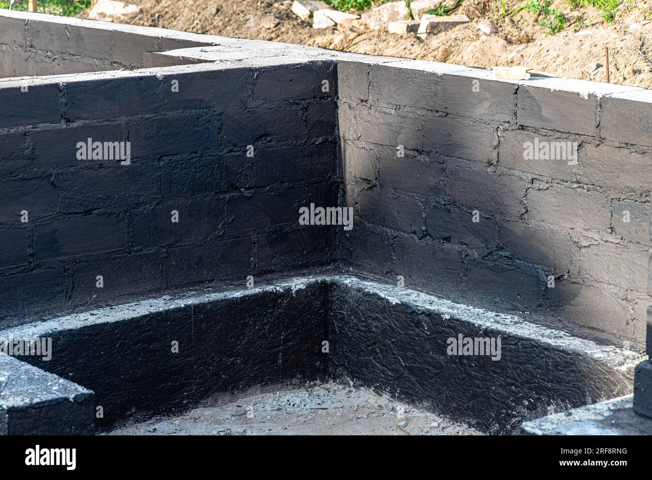 Footings made of concrete blocks painted with black dispersion asphalt ...