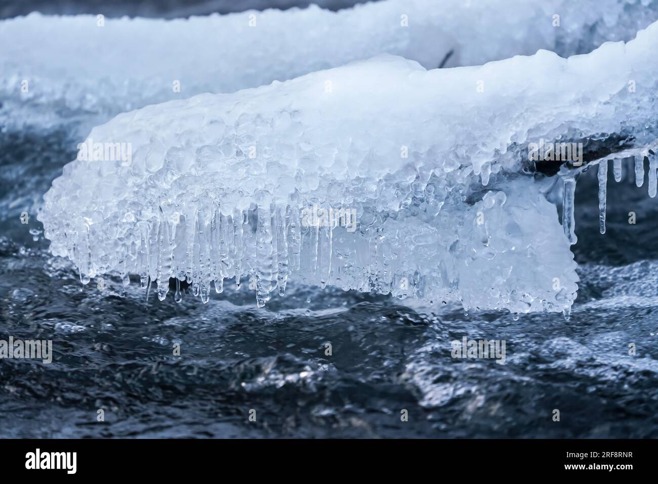 Ice on frozen river, closeup detail, water flows over rocks - winter ...