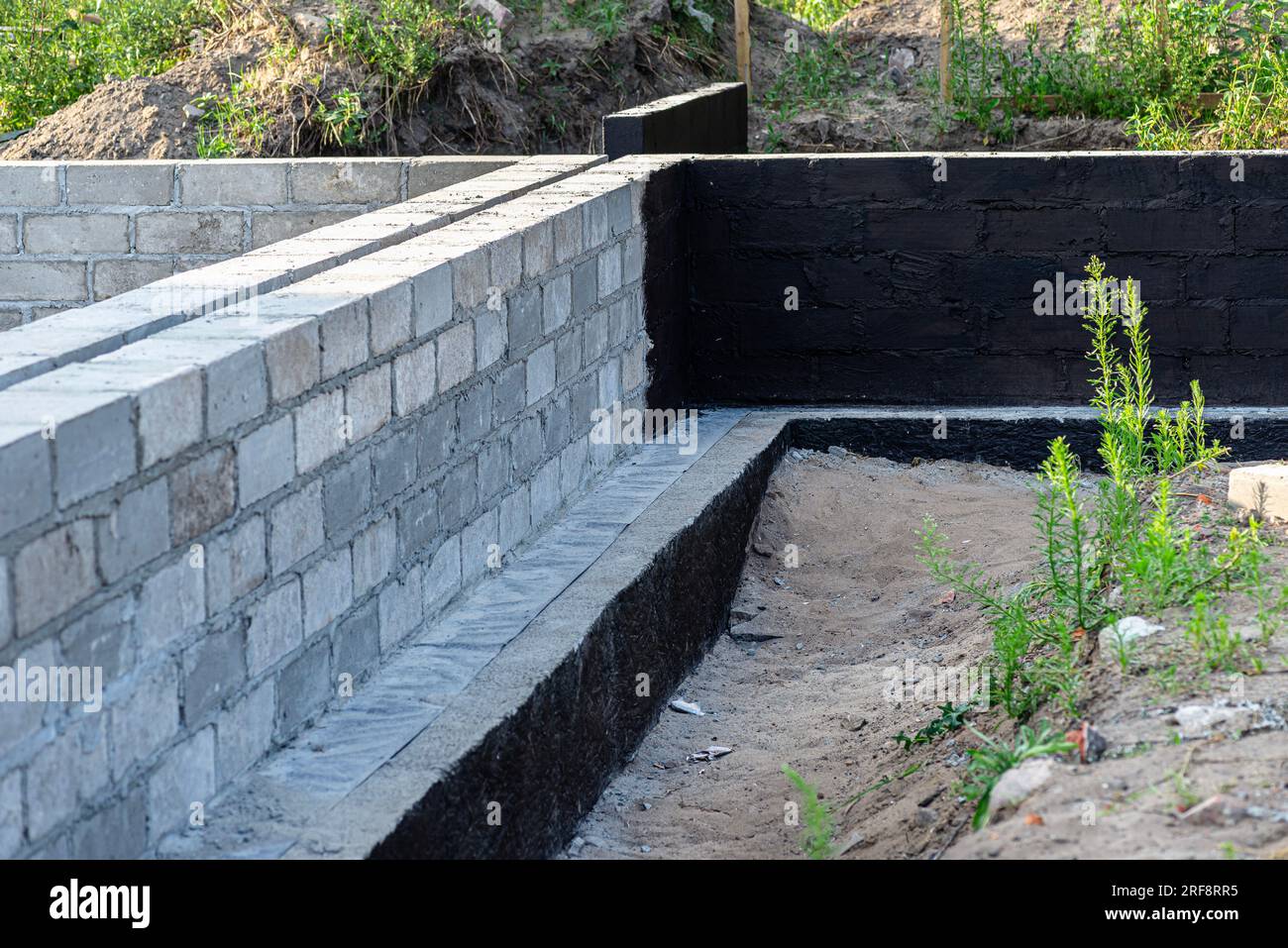 Footings made of concrete blocks painted with black dispersion asphalt ...