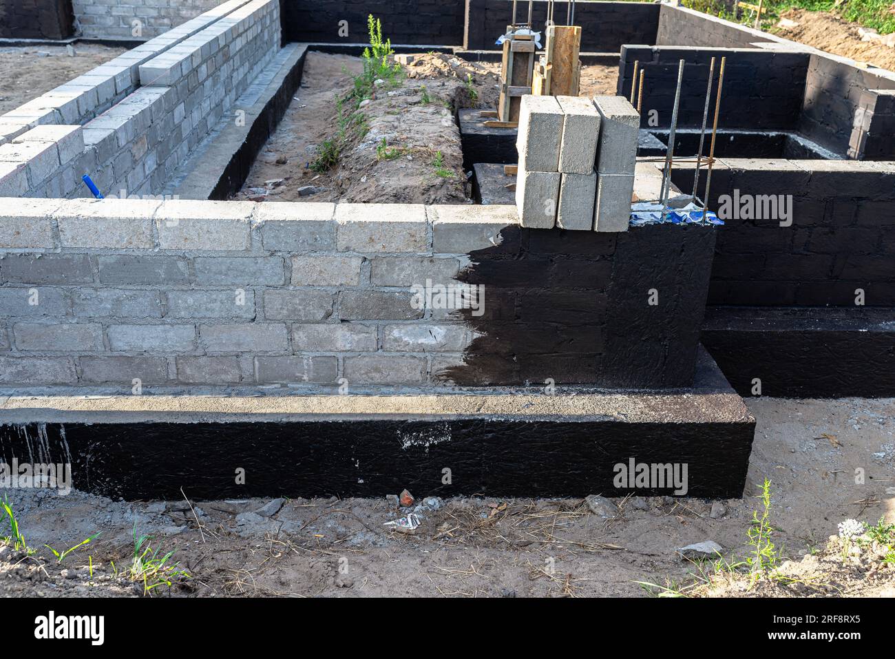 Footings made of concrete blocks painted with black dispersion asphalt ...
