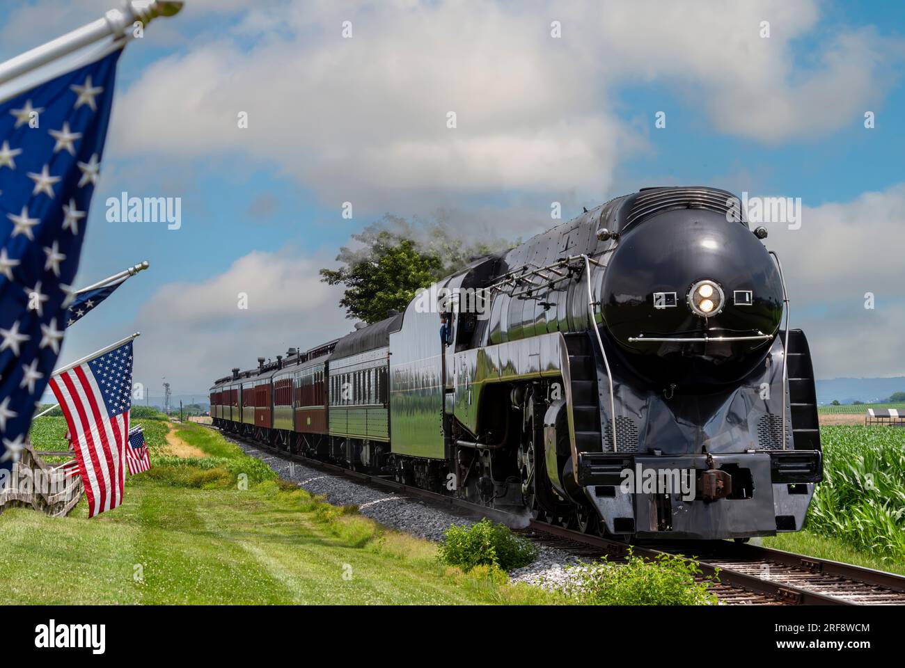 A Streamlined Steam Passenger Train Passing a Fence, in the Countryside ...