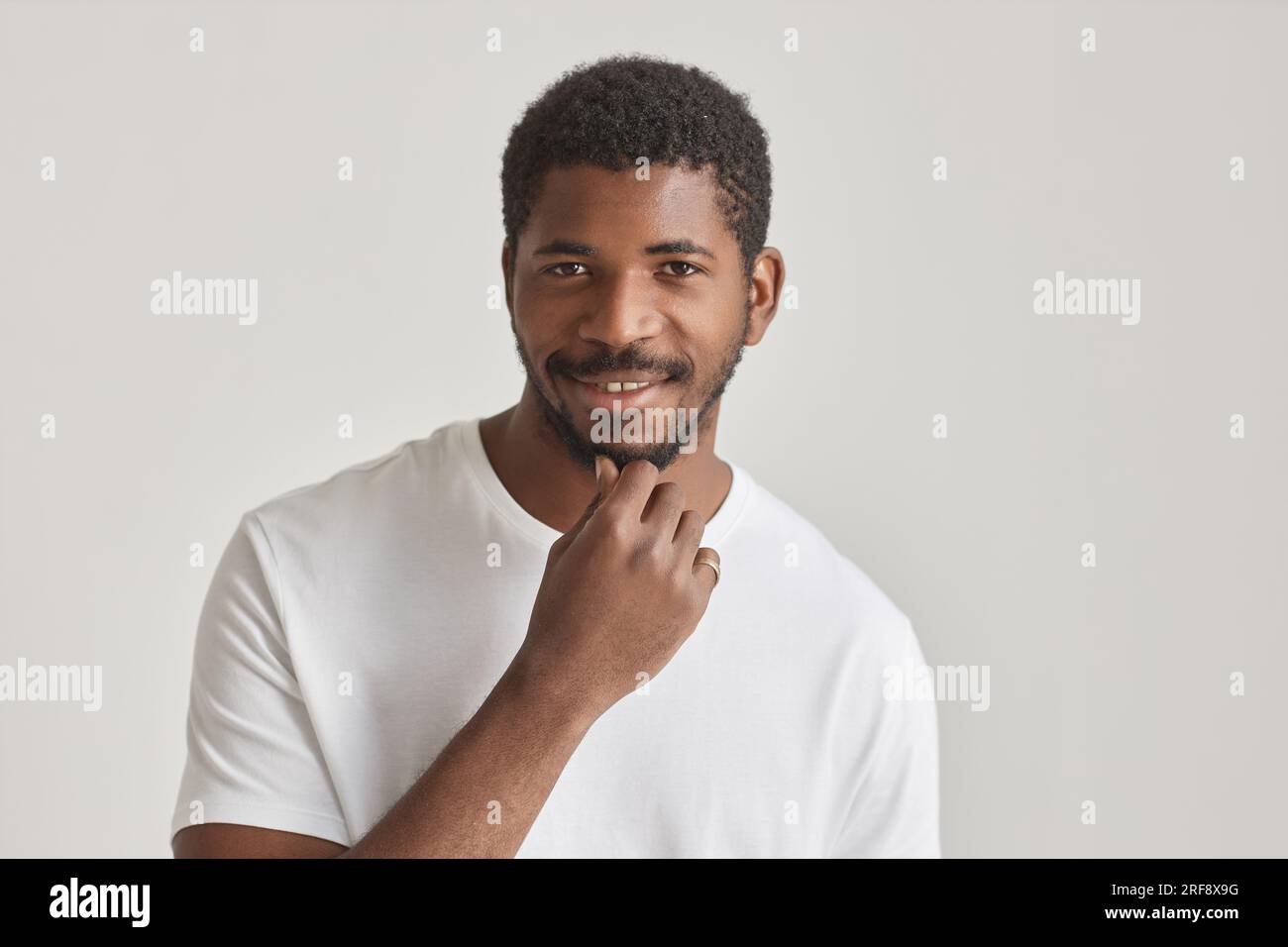 Minimal portrait of confident black man smiling at camera against white ...