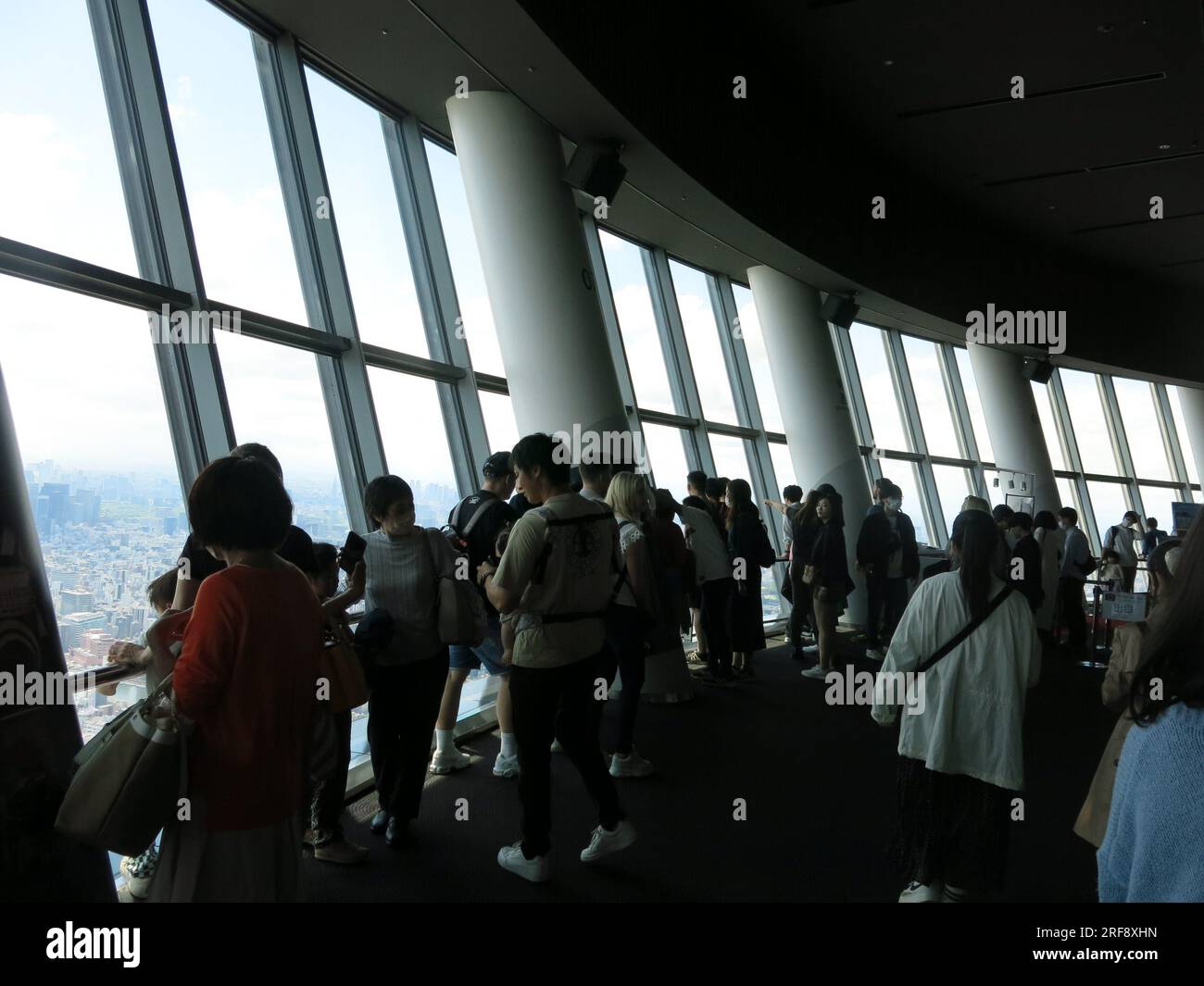 Tourists crowd at windows on one of the observation decks of the Tokyo ...