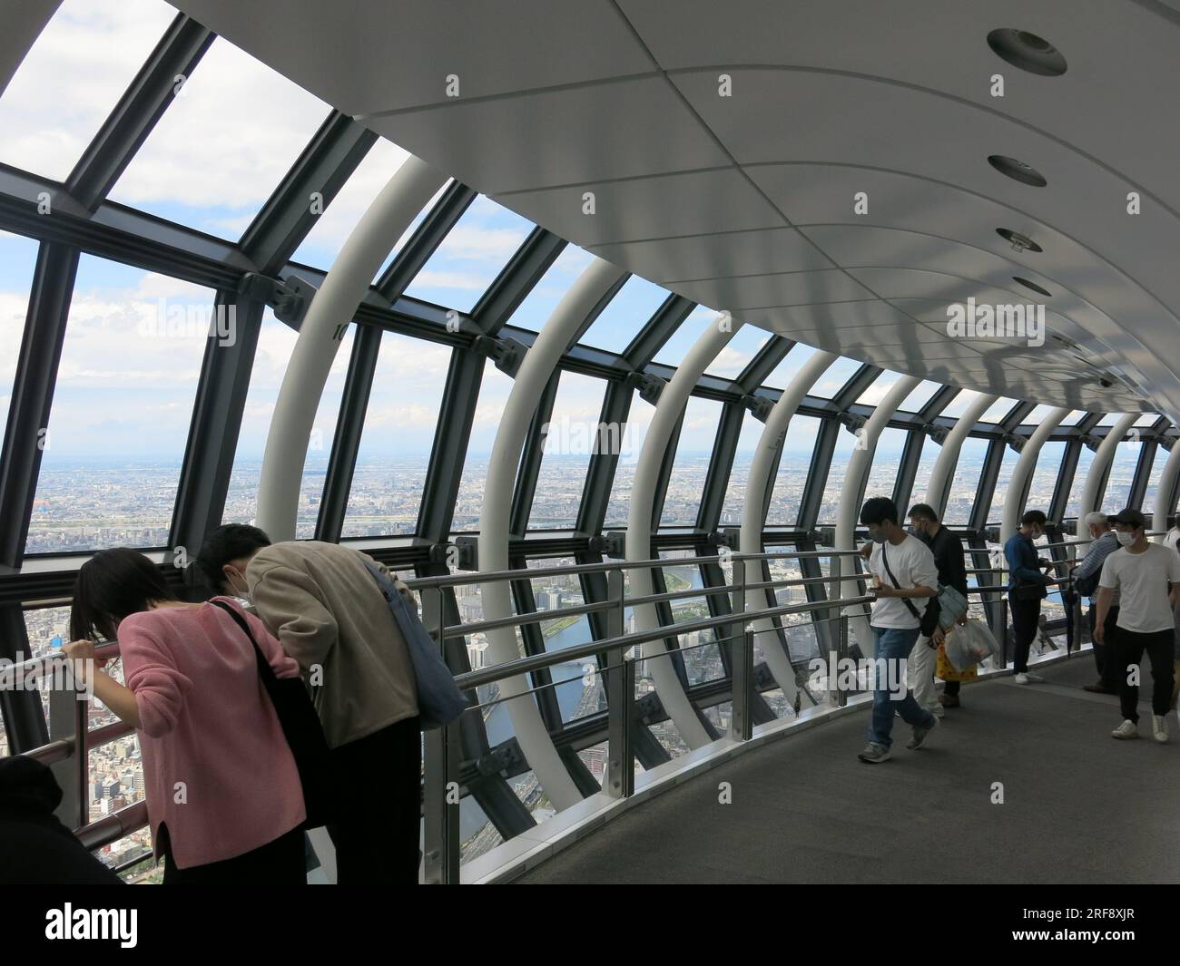 Tourists look over the railings at the windows of the observation deck ...