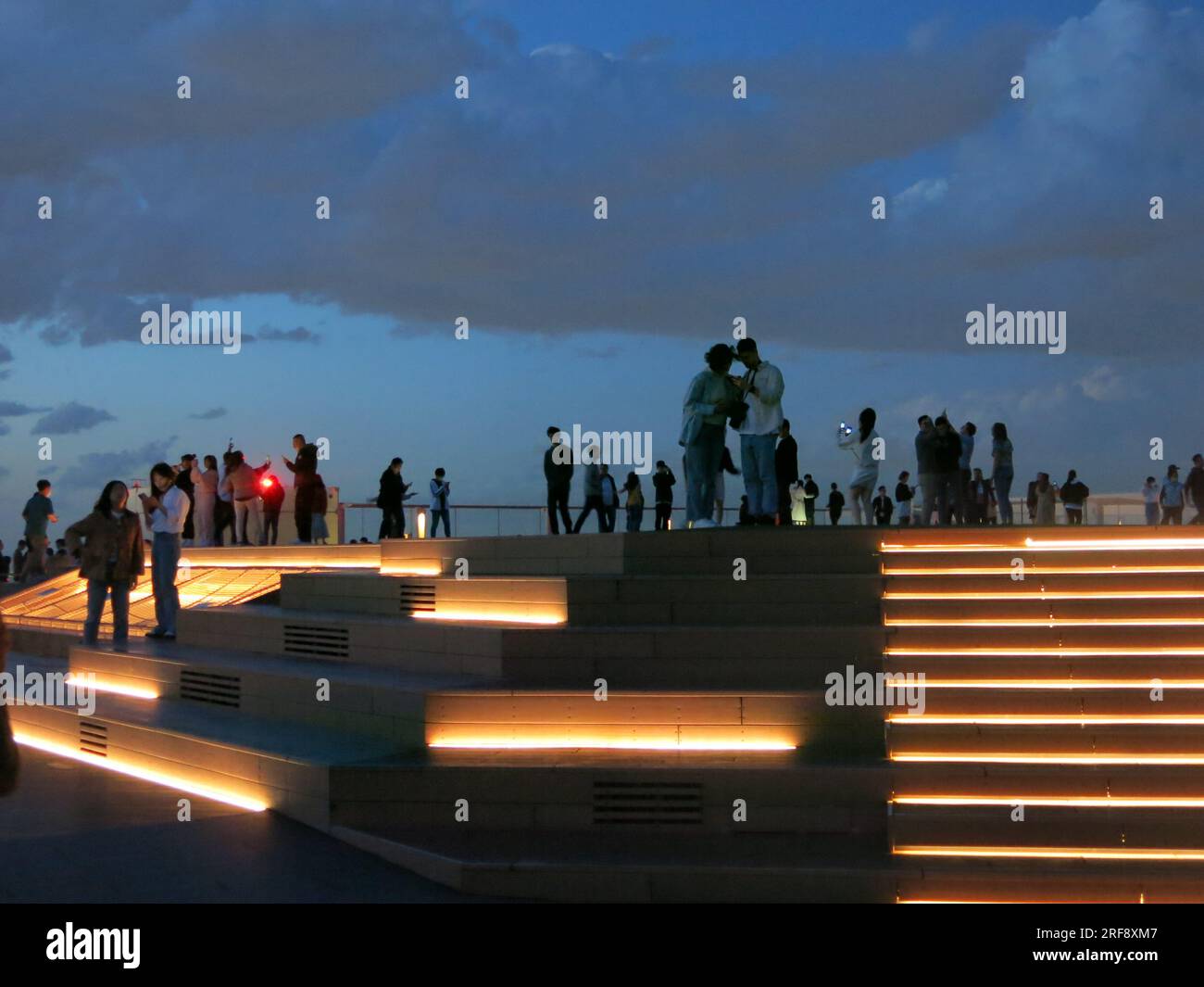 View of the illuminated steps with visitors on one of the platforms at ...