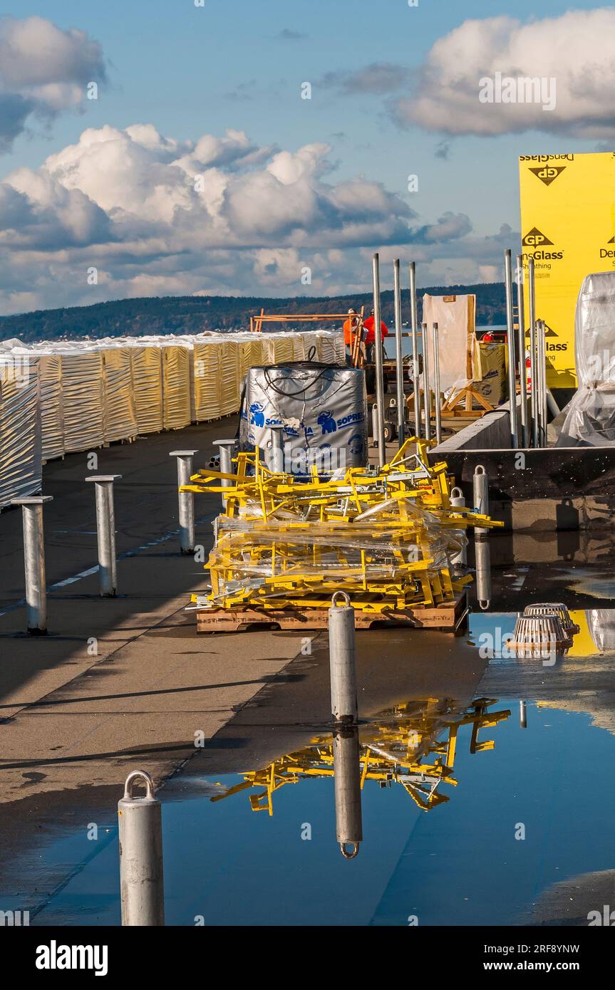 Yellow metal brackets on a pallet on the roof of a building under ...