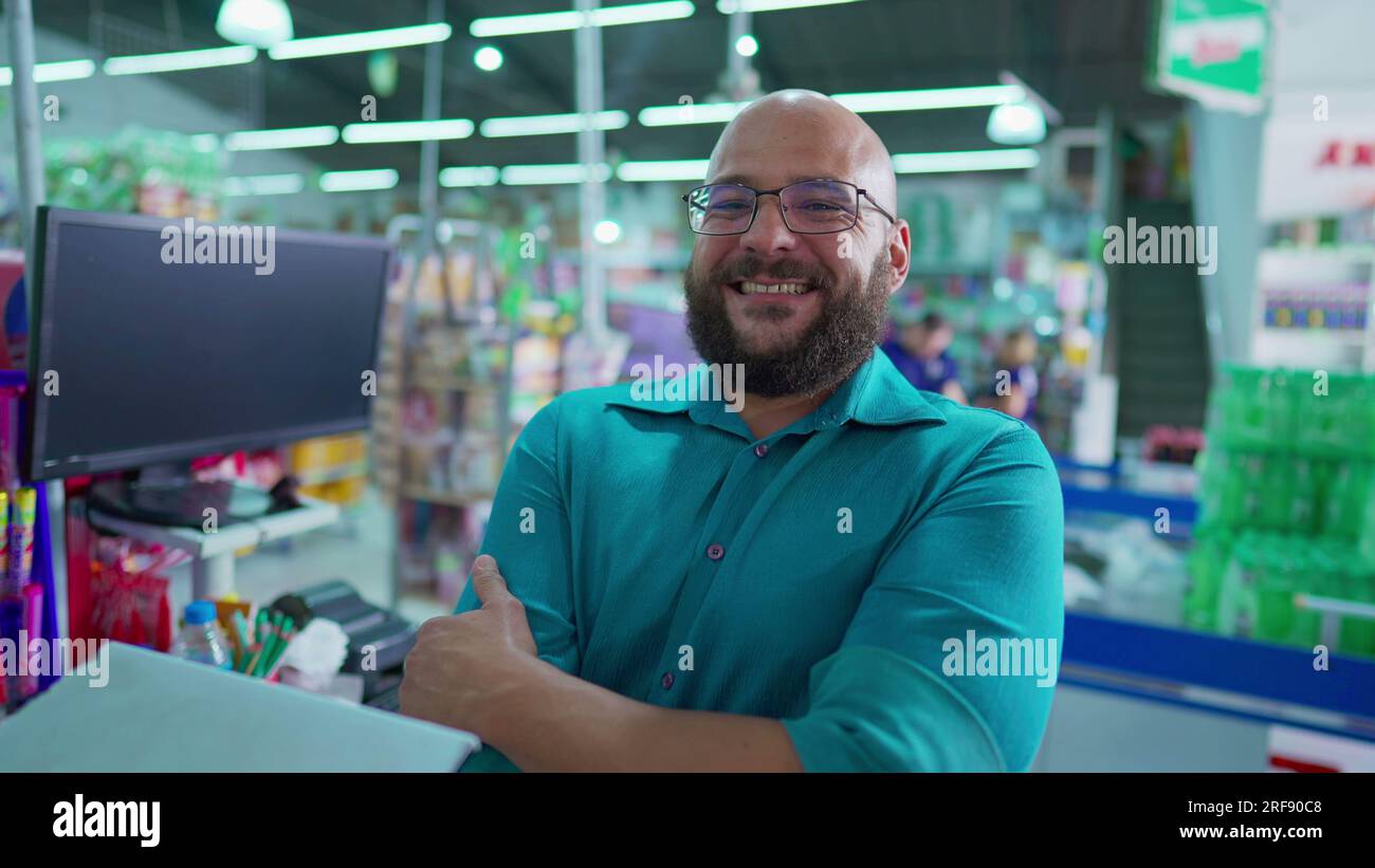 Portrait of a happy Brazilian employee of supermarket standing at ...