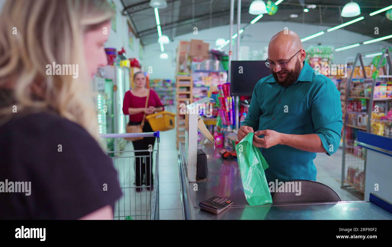 Grocery Store checkout scene in South America. Brazilian employee ...