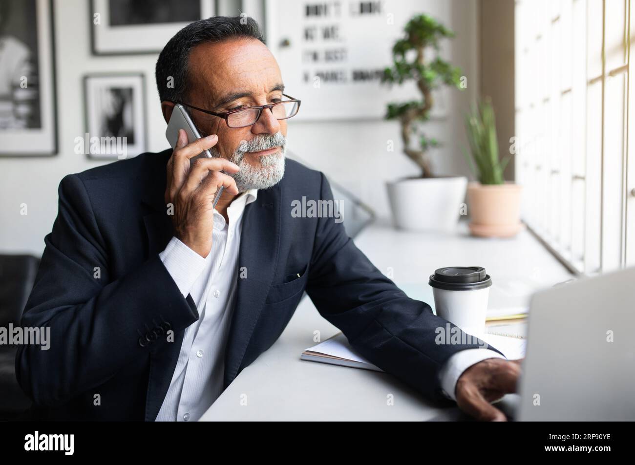Positive attractive caucasian senior businessman in suit and glasses ...