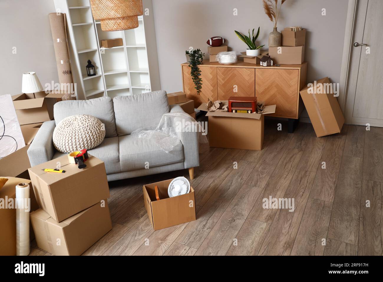 Cardboard boxes with things and sofa in living room on moving day Stock ...