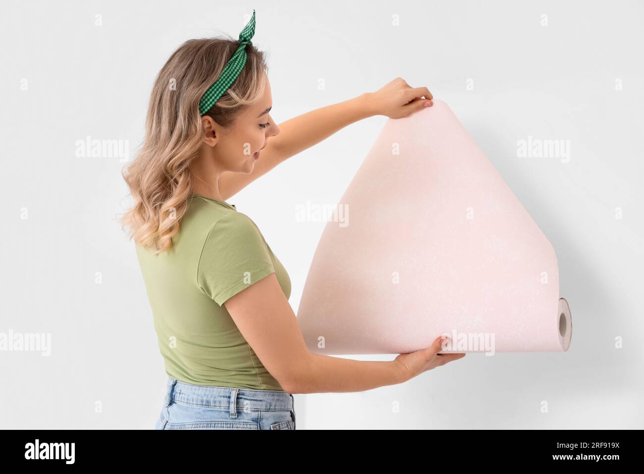 Young woman with wallpaper roll at home Stock Photo - Alamy