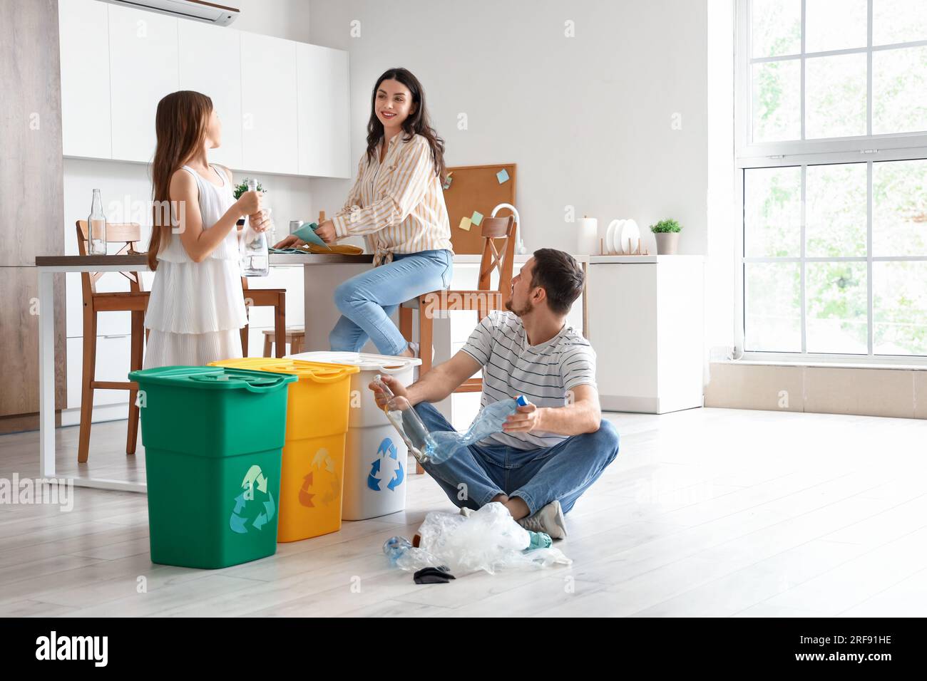 Family sorting garbage with recycle bins in kitchen Stock Photo - Alamy