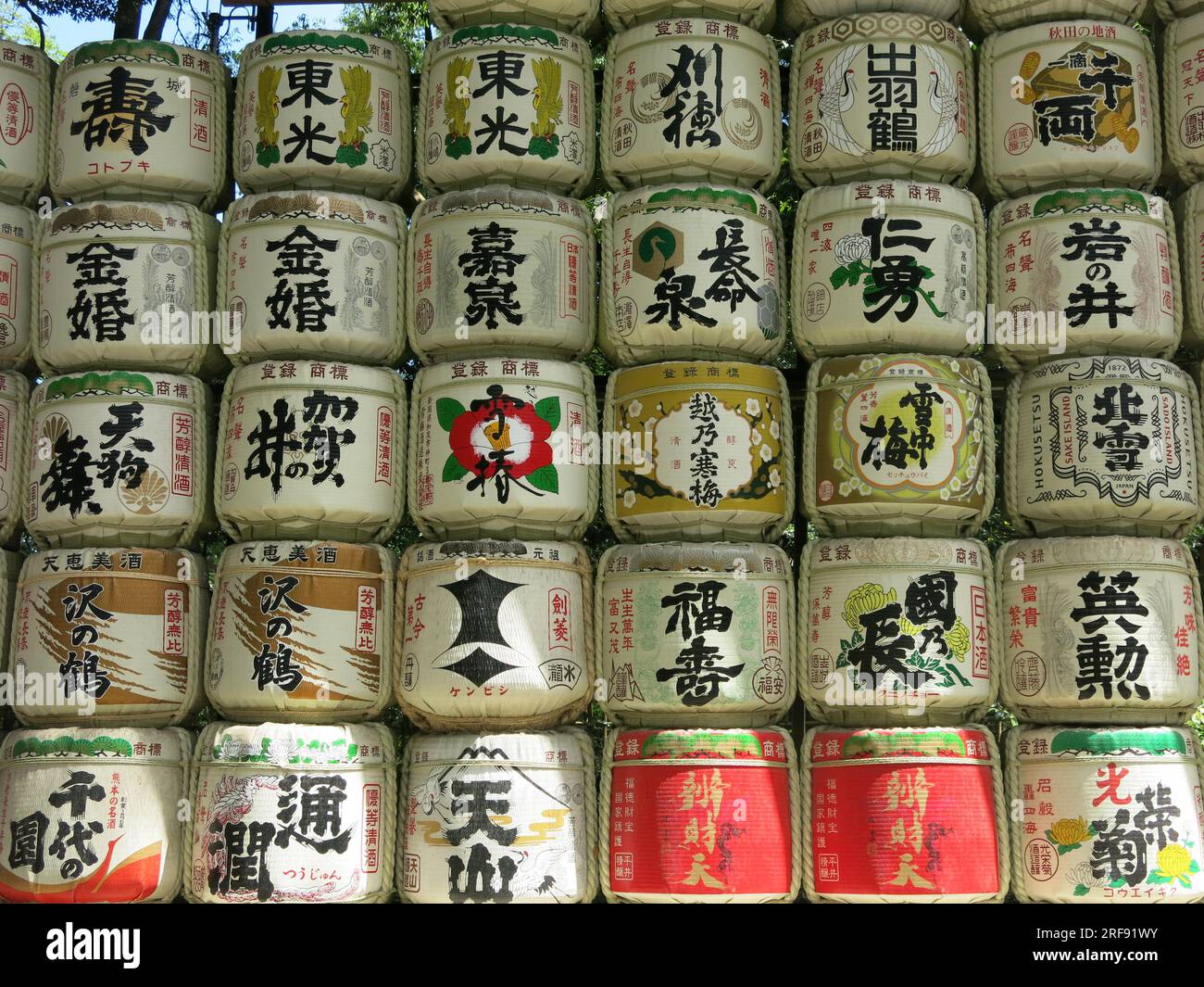 Sake barrels wrapped in straw are given as offerings to show the ...