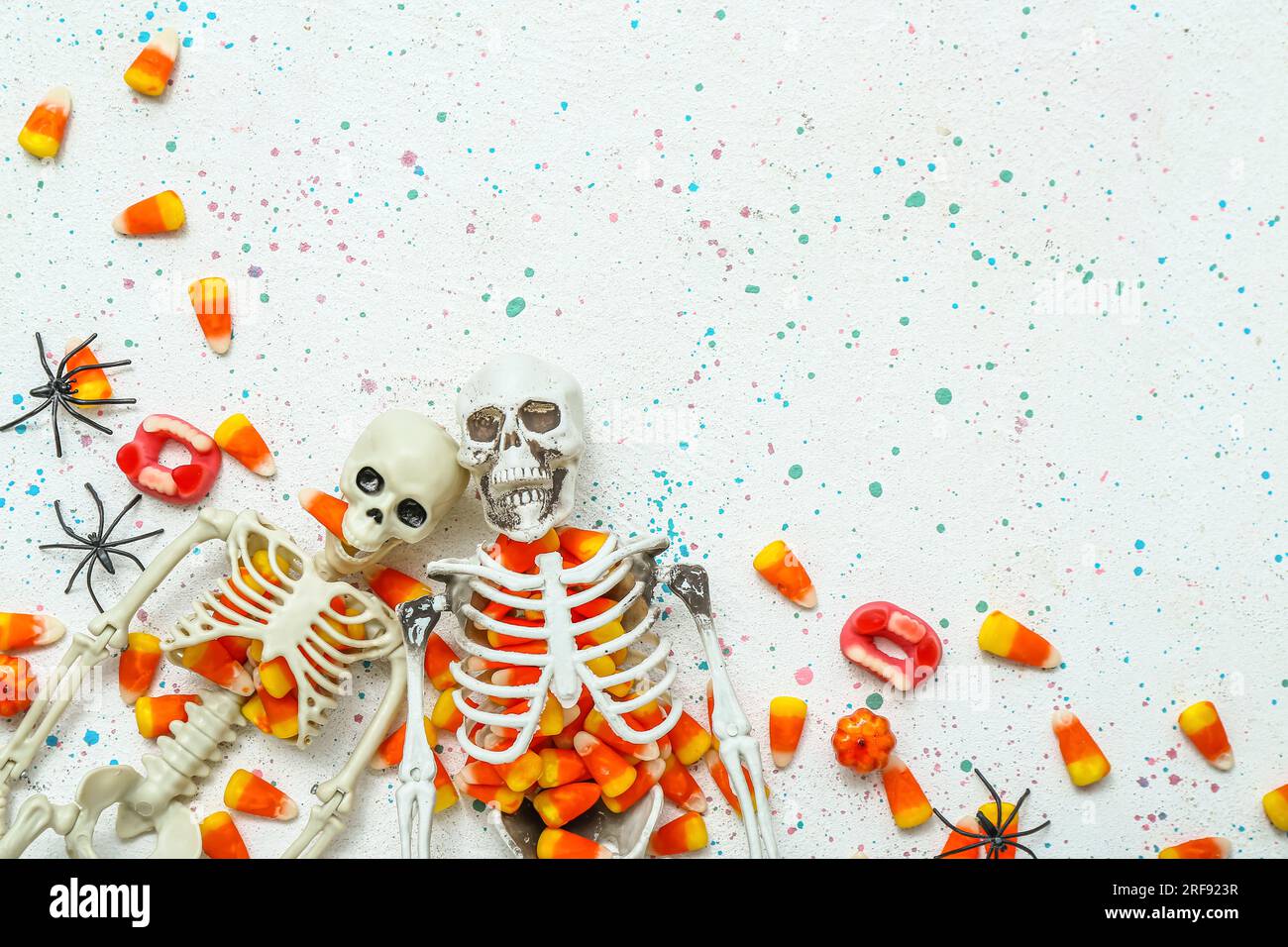 Tasty Halloween candy corns and skeletons on light background Stock ...