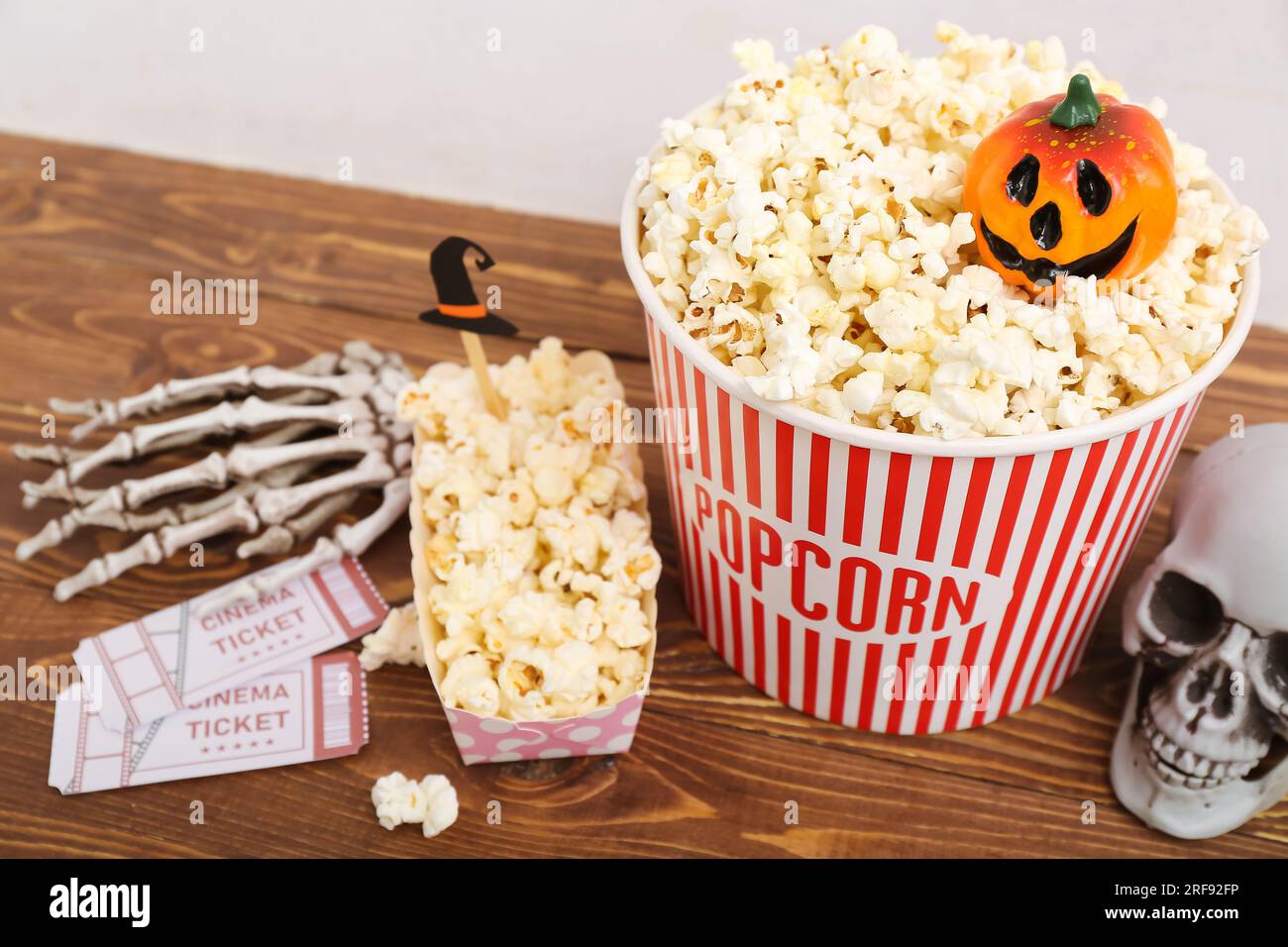 Composition with tasty popcorn, skull, skeleton hands and cinema ...