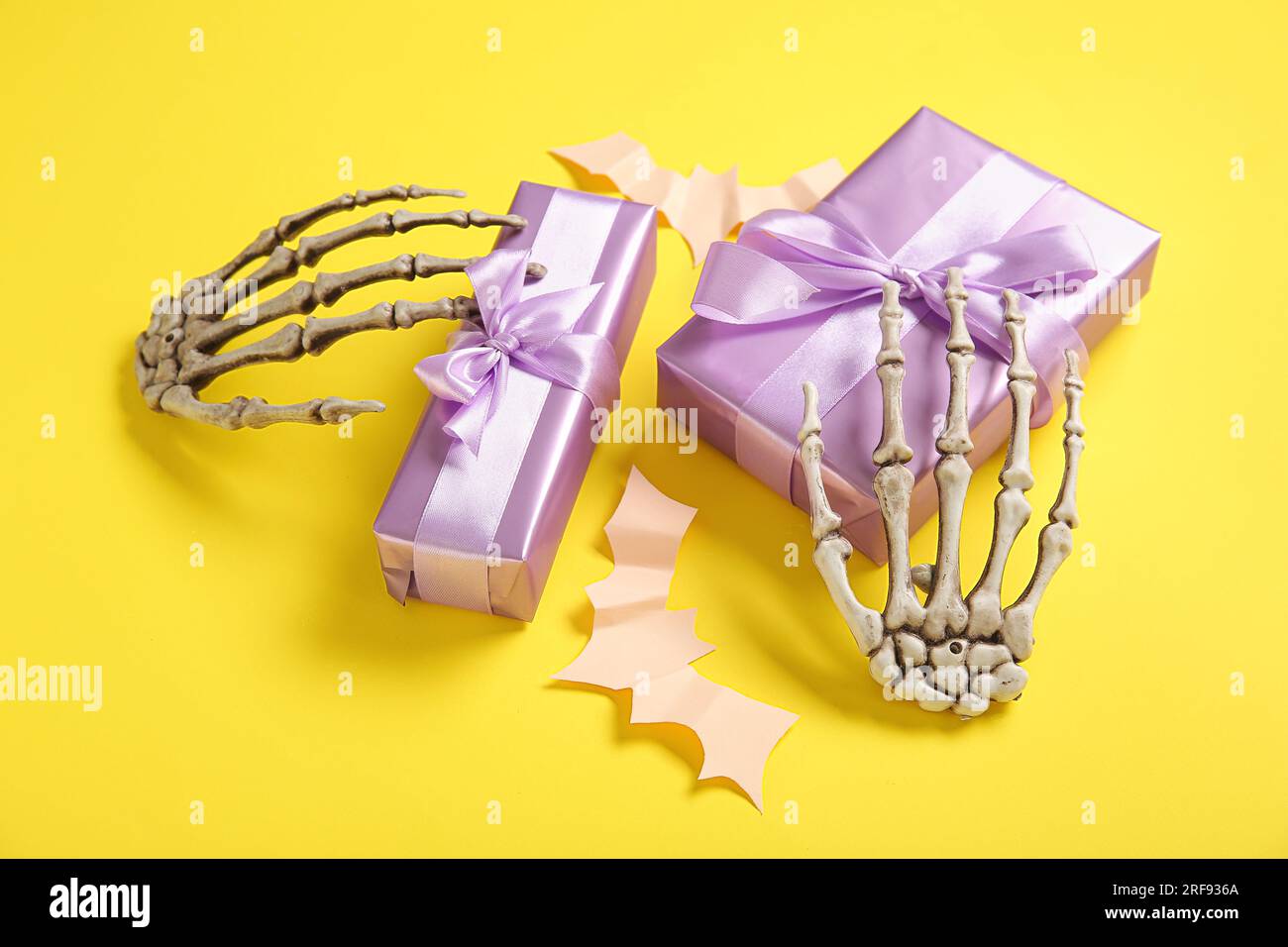 Composition with beautiful gift boxes, skeleton hands and bats made of ...