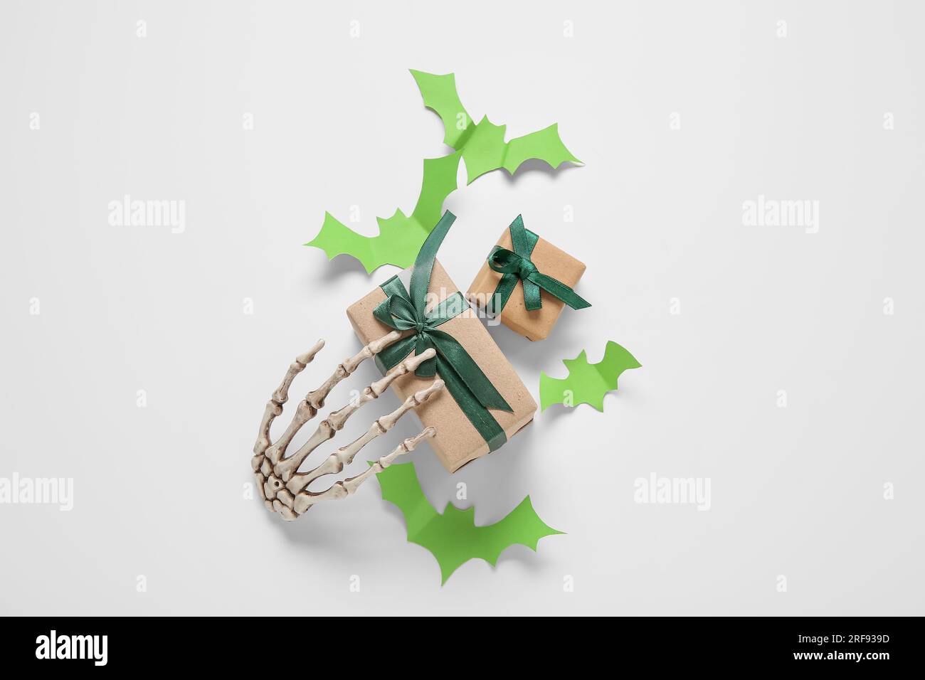 Composition with beautiful gift boxes, skeleton hand and bats made of ...