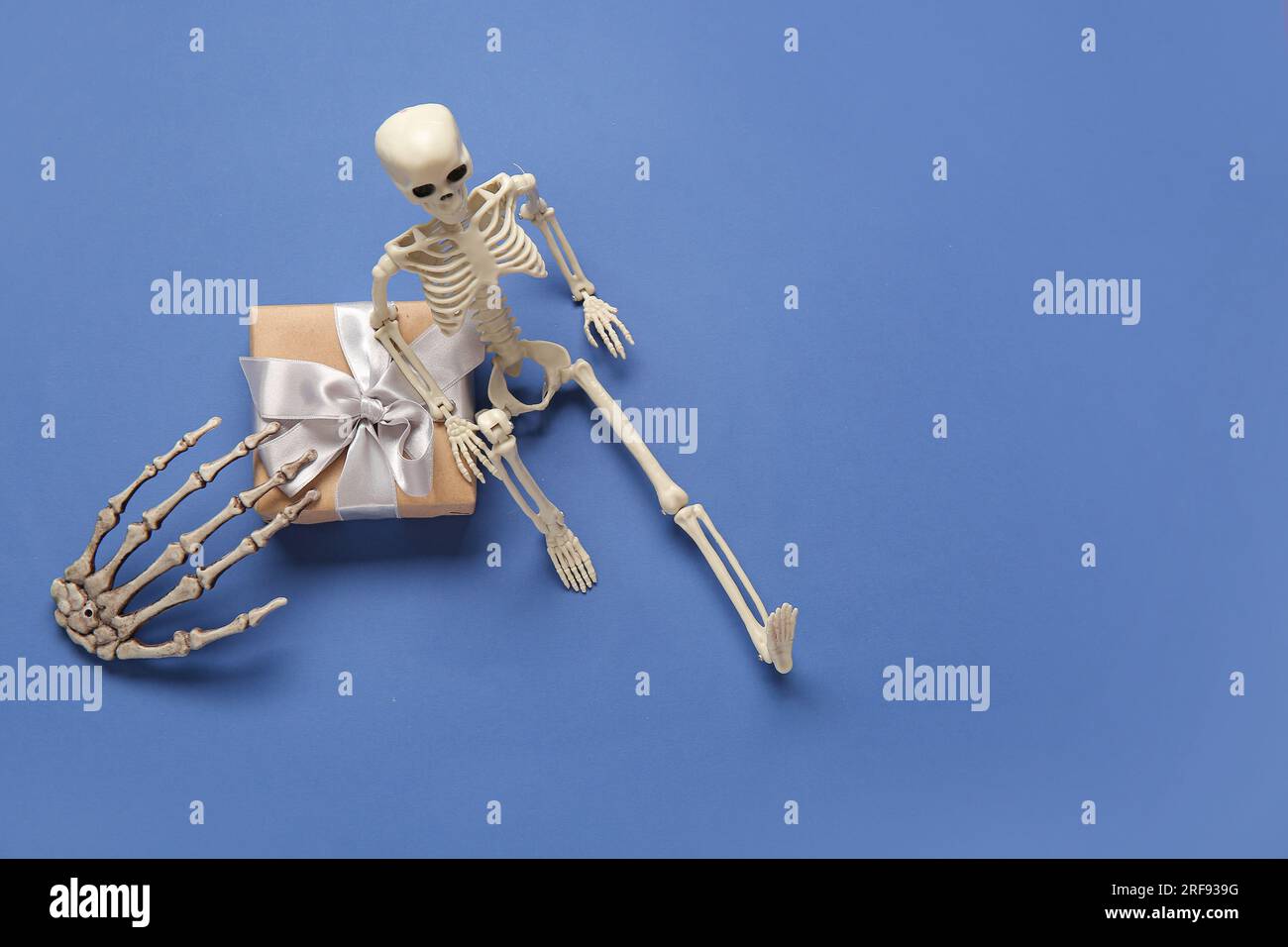 Composition with beautiful gift box, skeleton and hand for Halloween on ...
