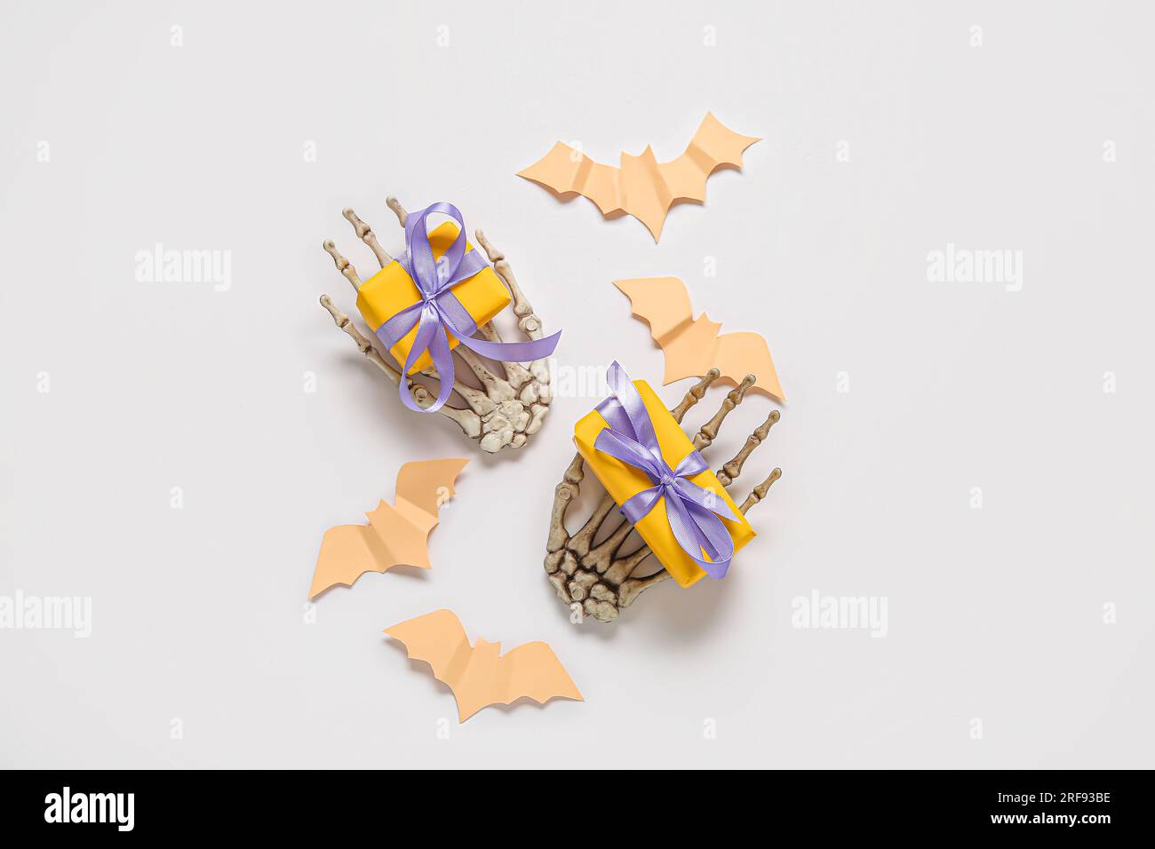 Composition with beautiful gift boxes, skeleton hands and bats made of ...
