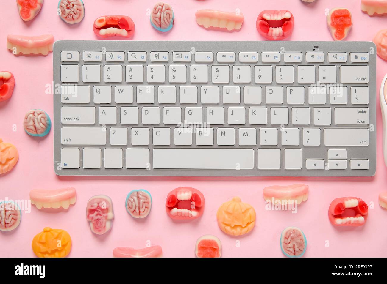 Composition with modern computer keyboard and different tasty candies ...