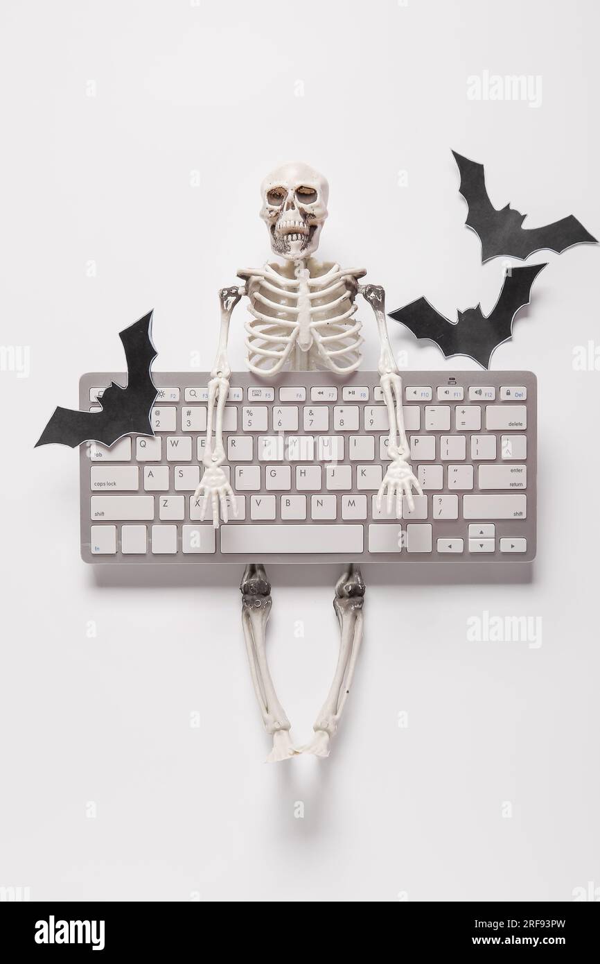 Composition with modern computer keyboard, skeleton and paper bats for ...