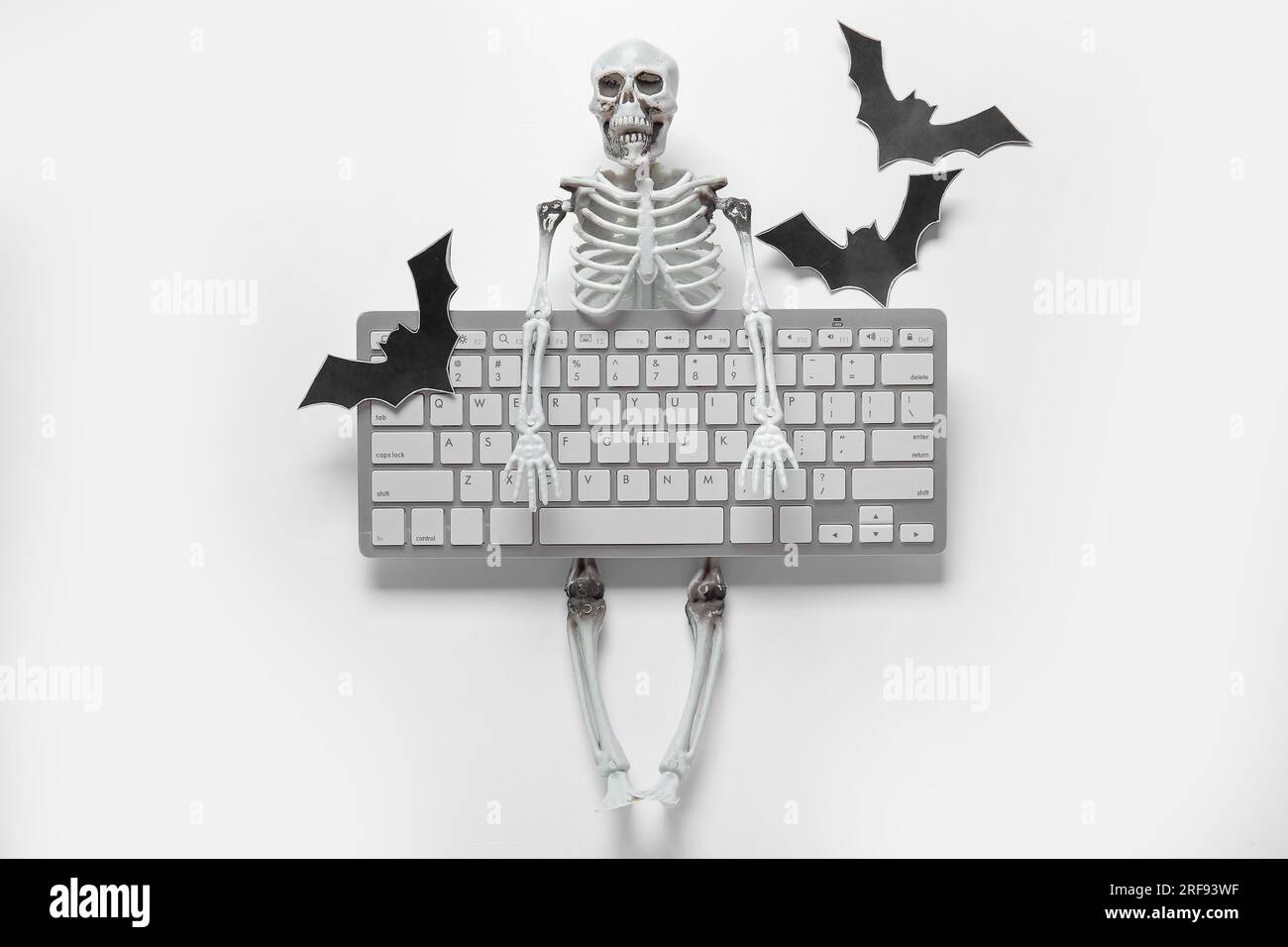Composition with modern computer keyboard, skeleton and paper bats for ...