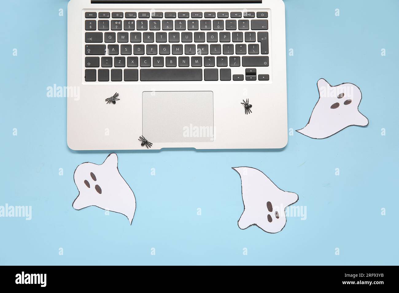 Composition with modern laptop, spiders and paper ghosts for Halloween ...