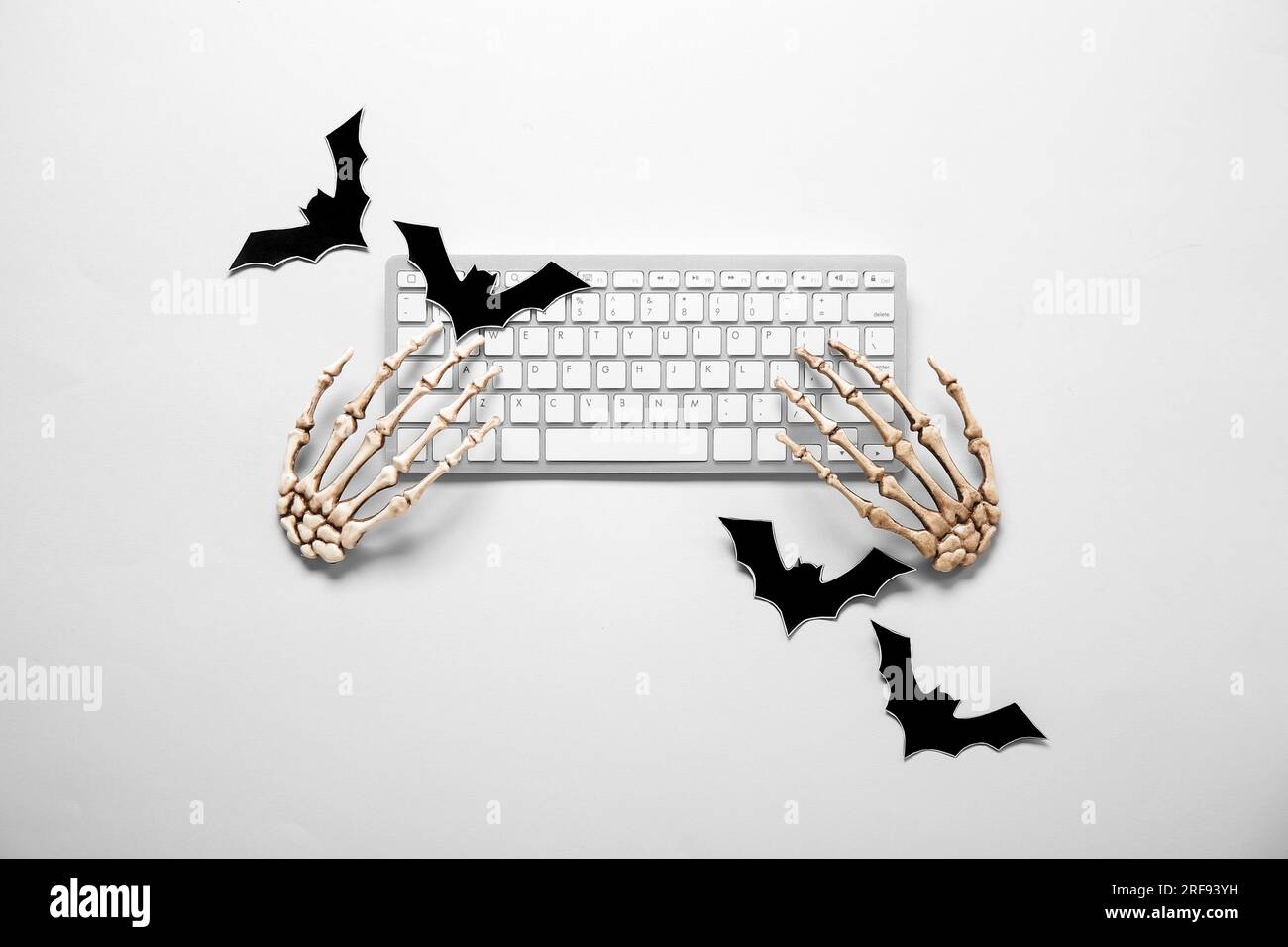 Composition with modern computer keyboard, skeleton hands and paper ...