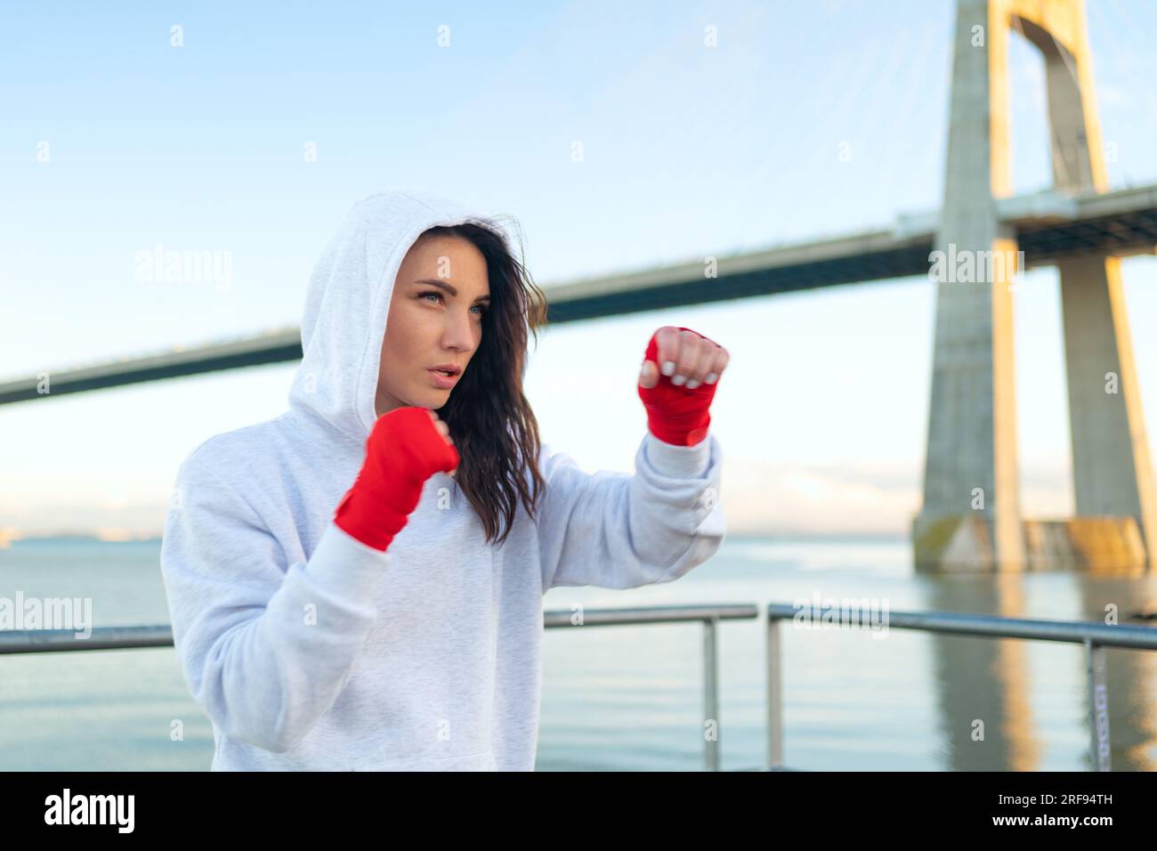 Woman shadow boxing with her hands wrapped in red boxing tapes with ...