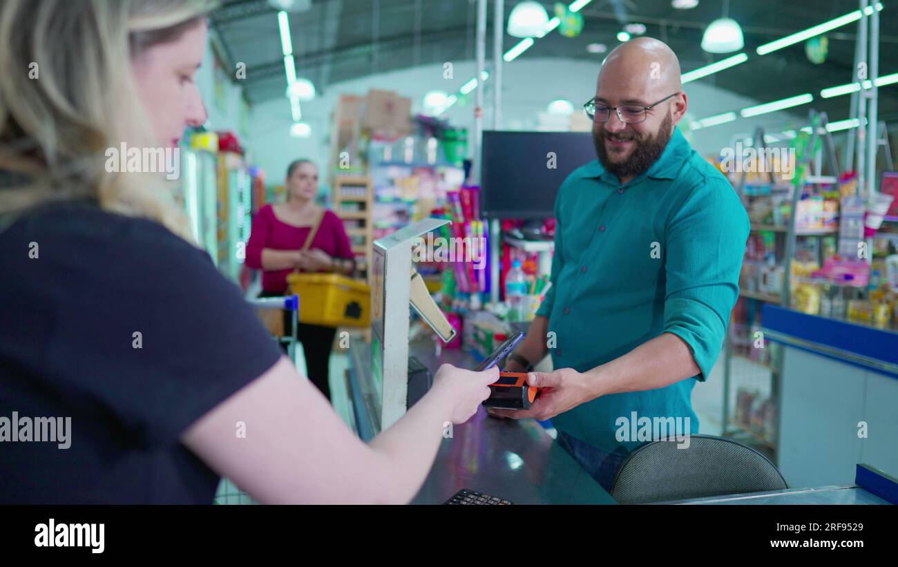 Supermarket Checkout of Customer Making Contactless Payment, Employee ...