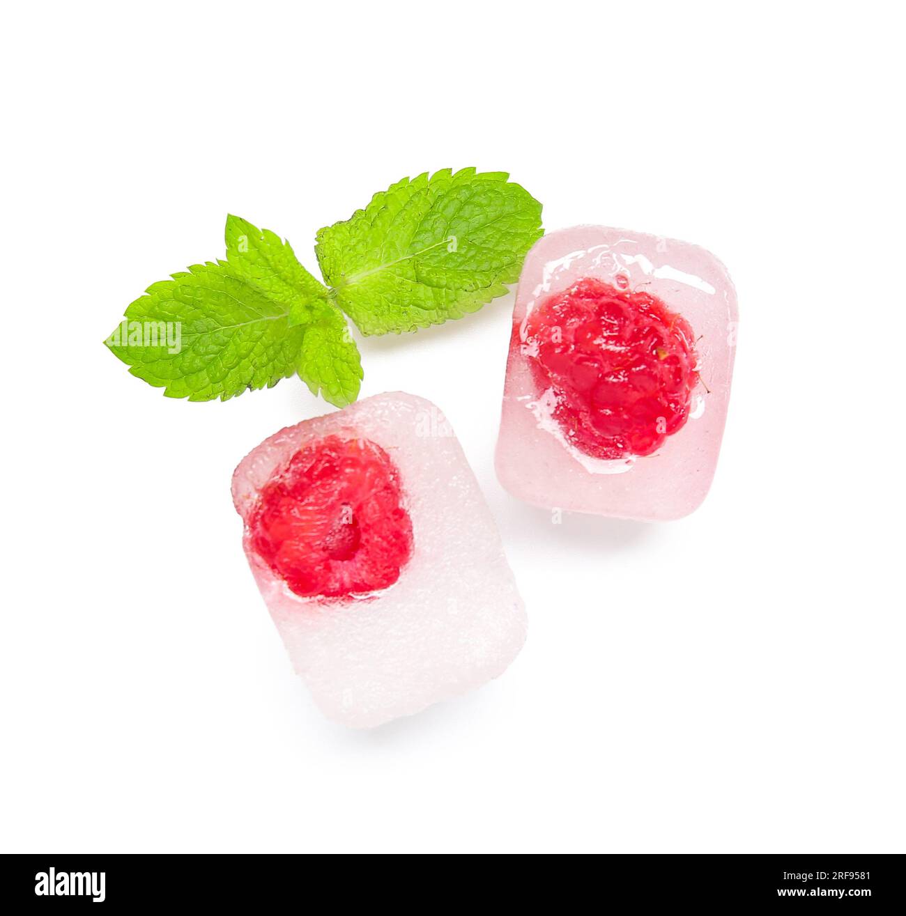 Frozen raspberries in ice cubes and mint on white background Stock ...